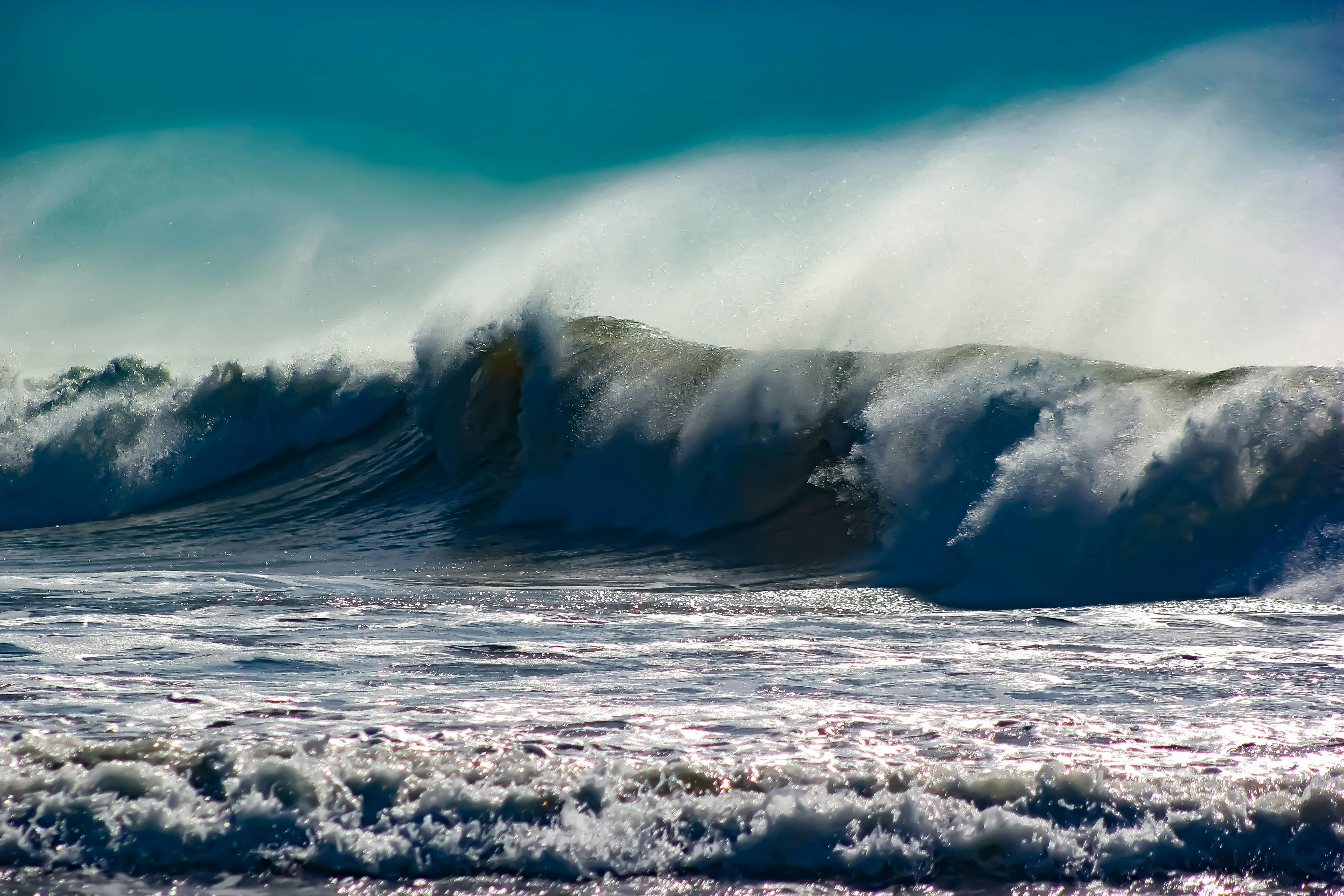 Dynamic Ocean Wave Crashing under Blue Skies · Free Stock Photo