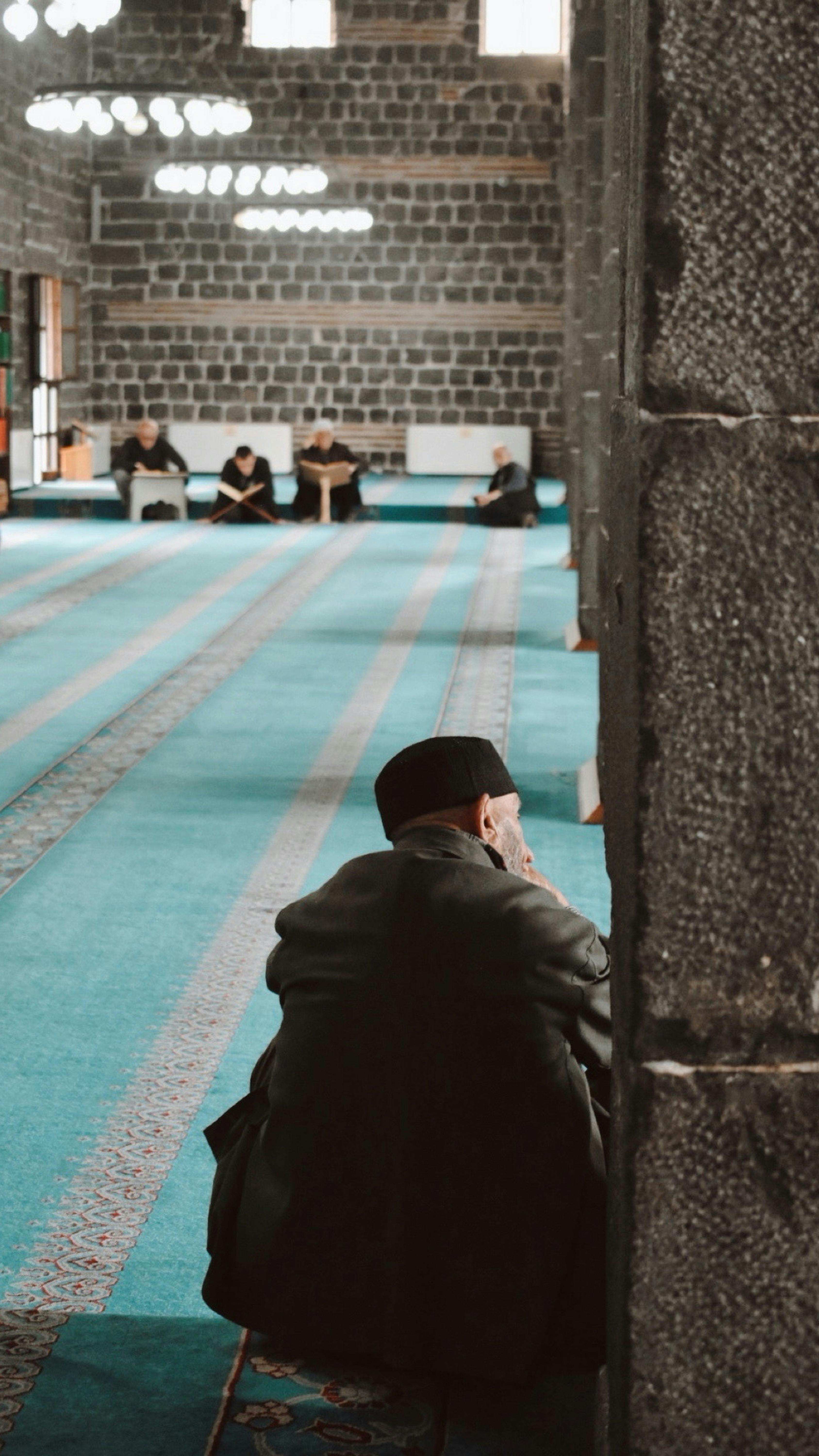 Contemplative Moment Inside a Quiet Mosque · Free Stock Photo