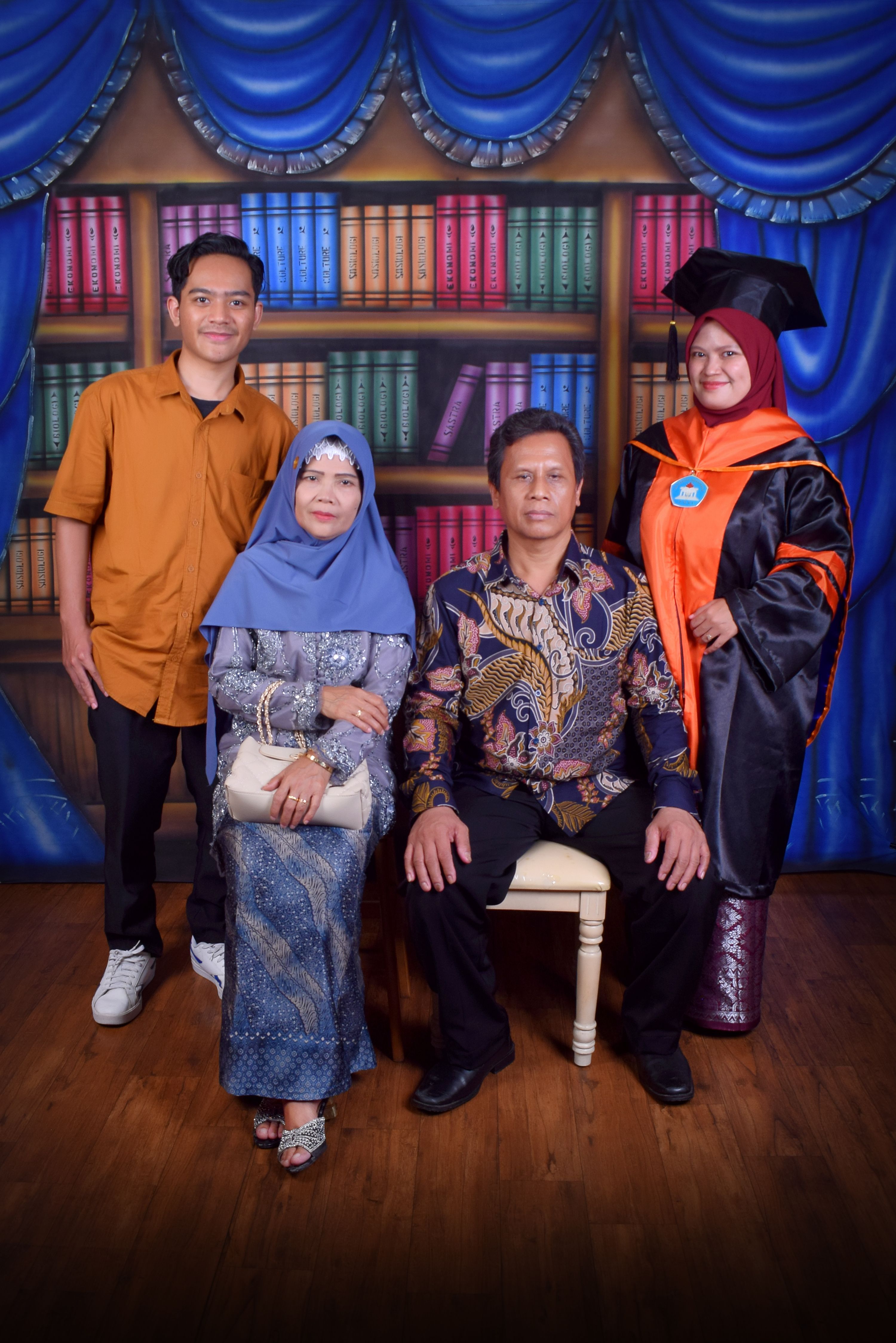 Family Graduation Portrait with Bookshelf Backdrop · Free Stock Photo