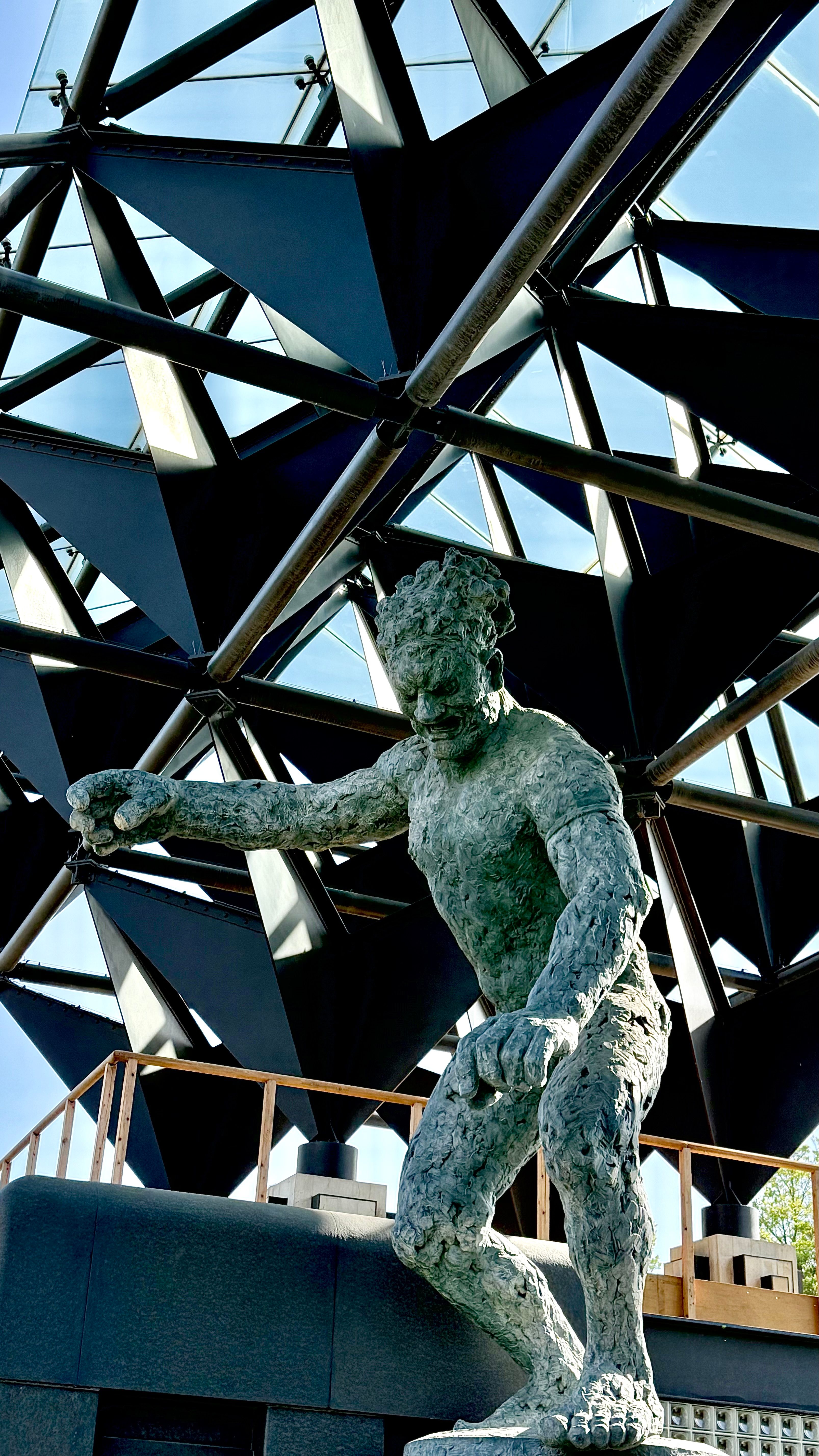 Dynamic Bronze Sculpture in Modern Architecture Setting · Free Stock Photo