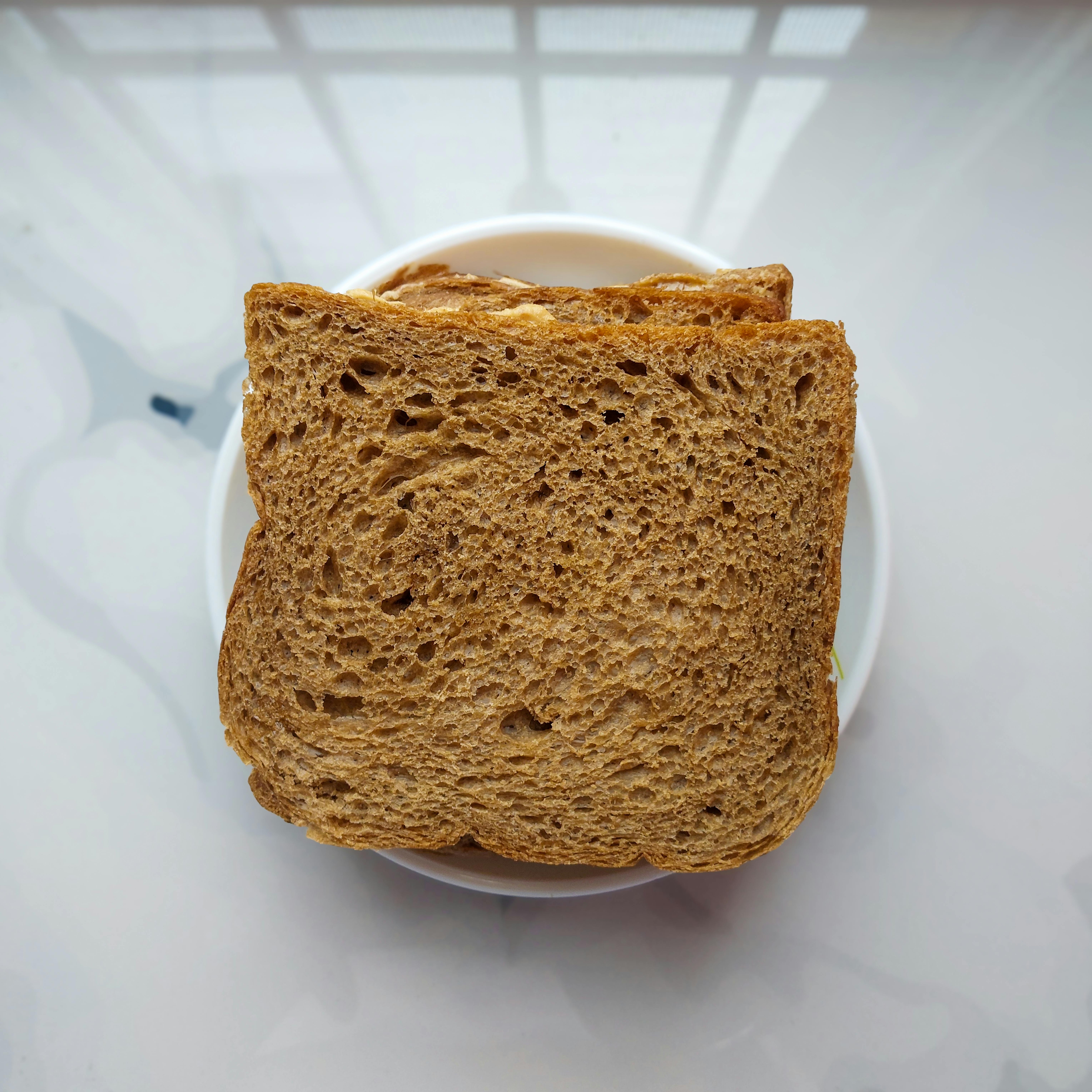 Top View of Fresh Brown Bread Slices on Plate · Free Stock Photo