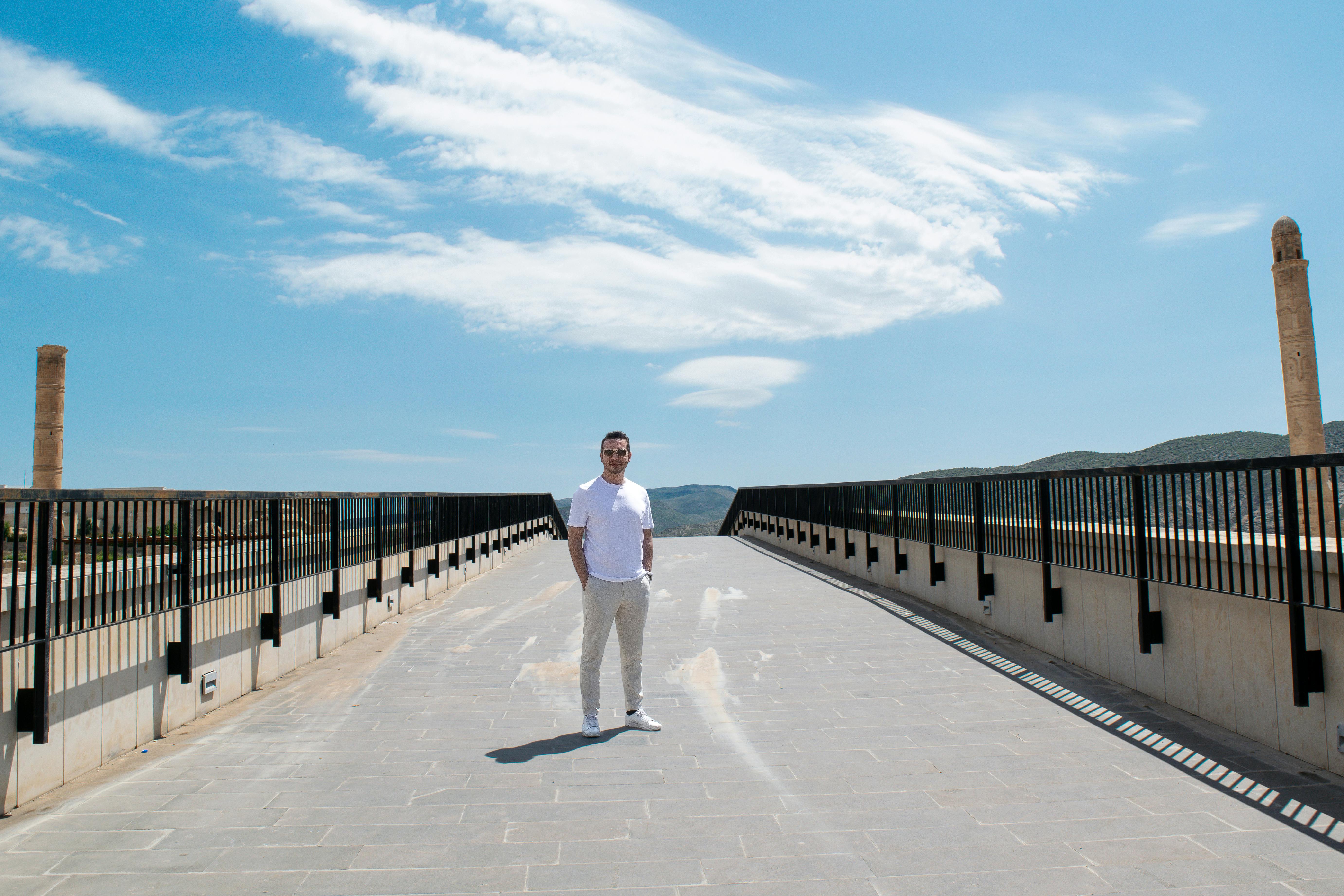 Man Standing on Bridge under Blue Sky · Free Stock Photo