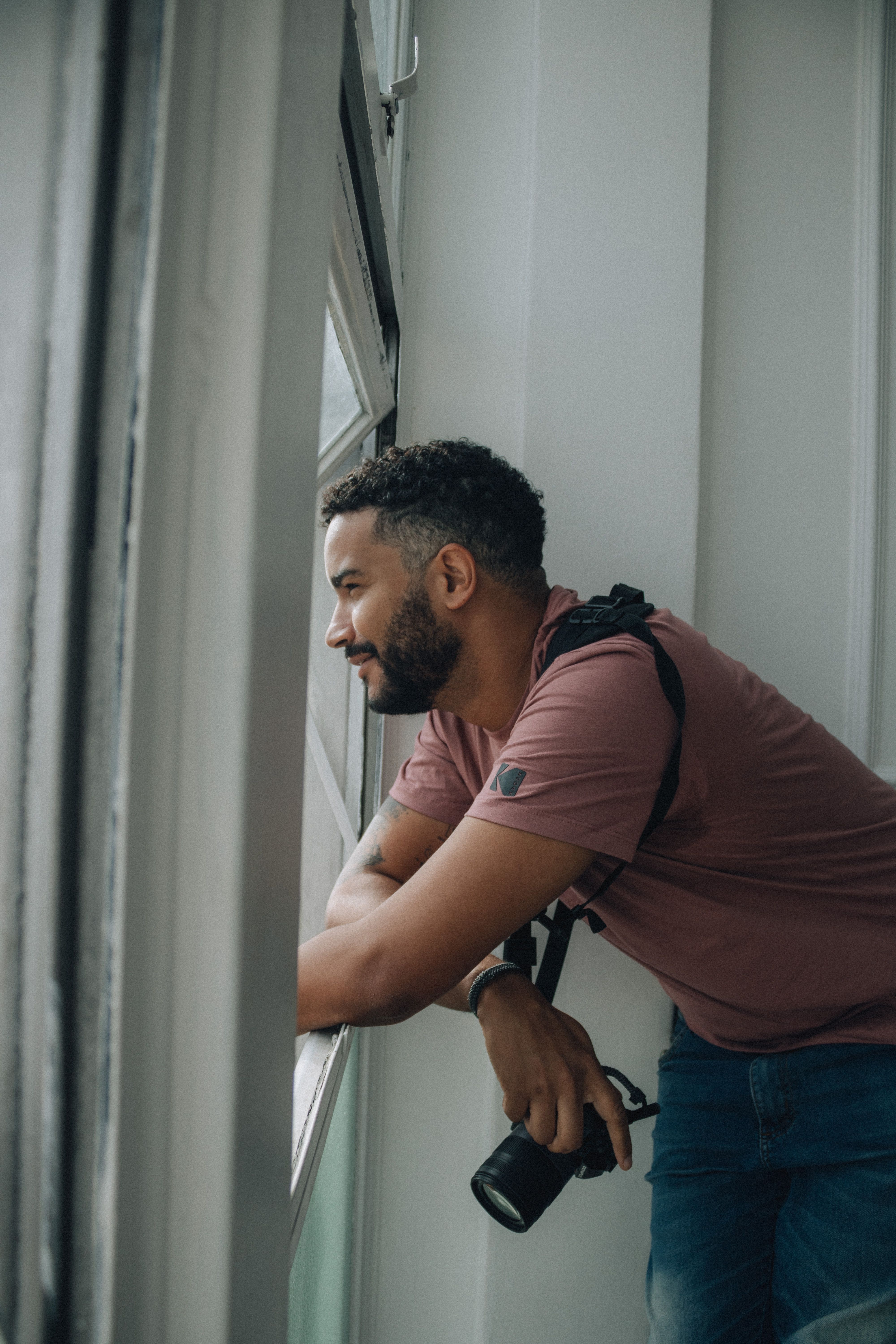 Male Photographer Leaning Out of Window · Free Stock Photo