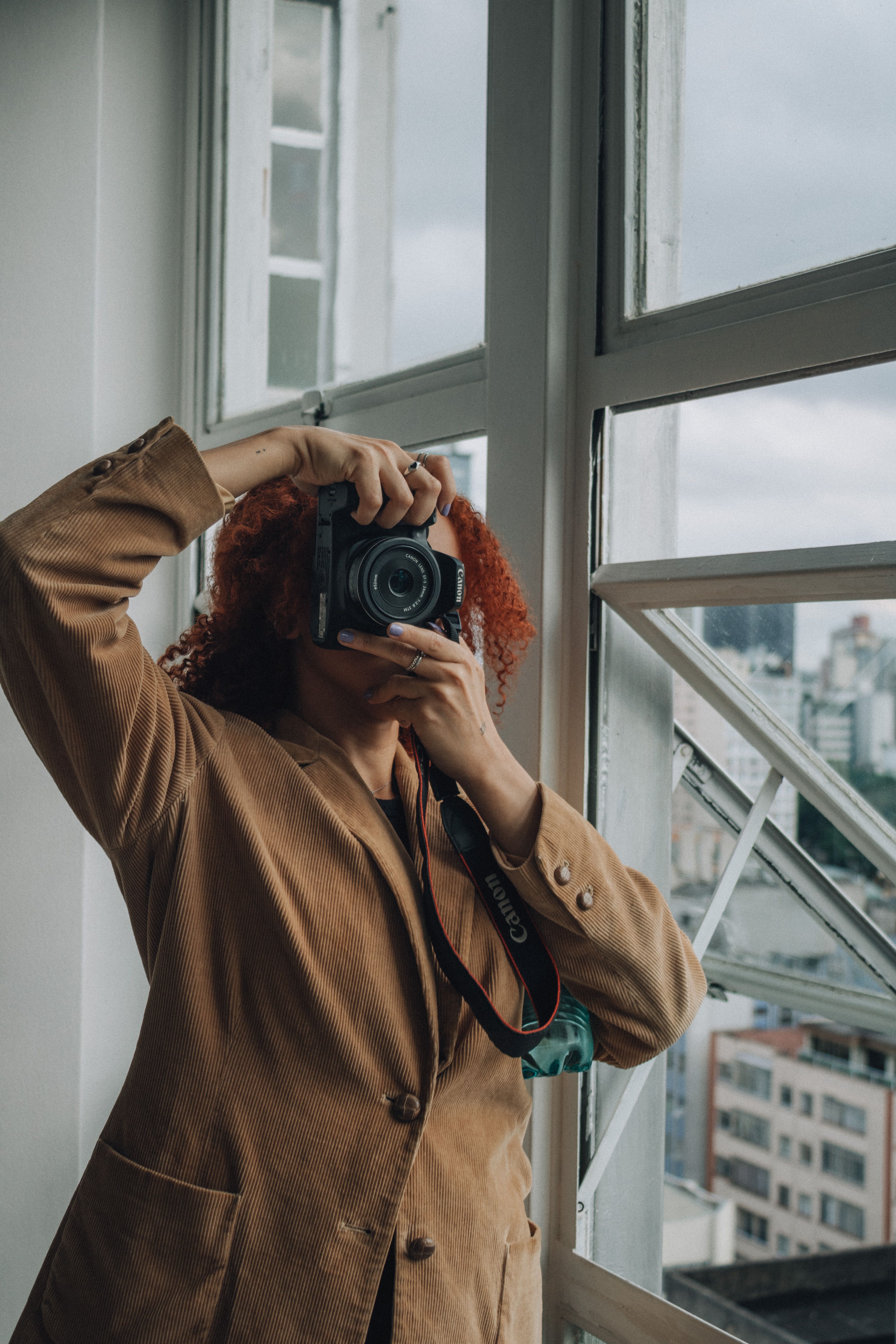 Urban Photographer Taking Pictures by the Window · Free Stock Photo
