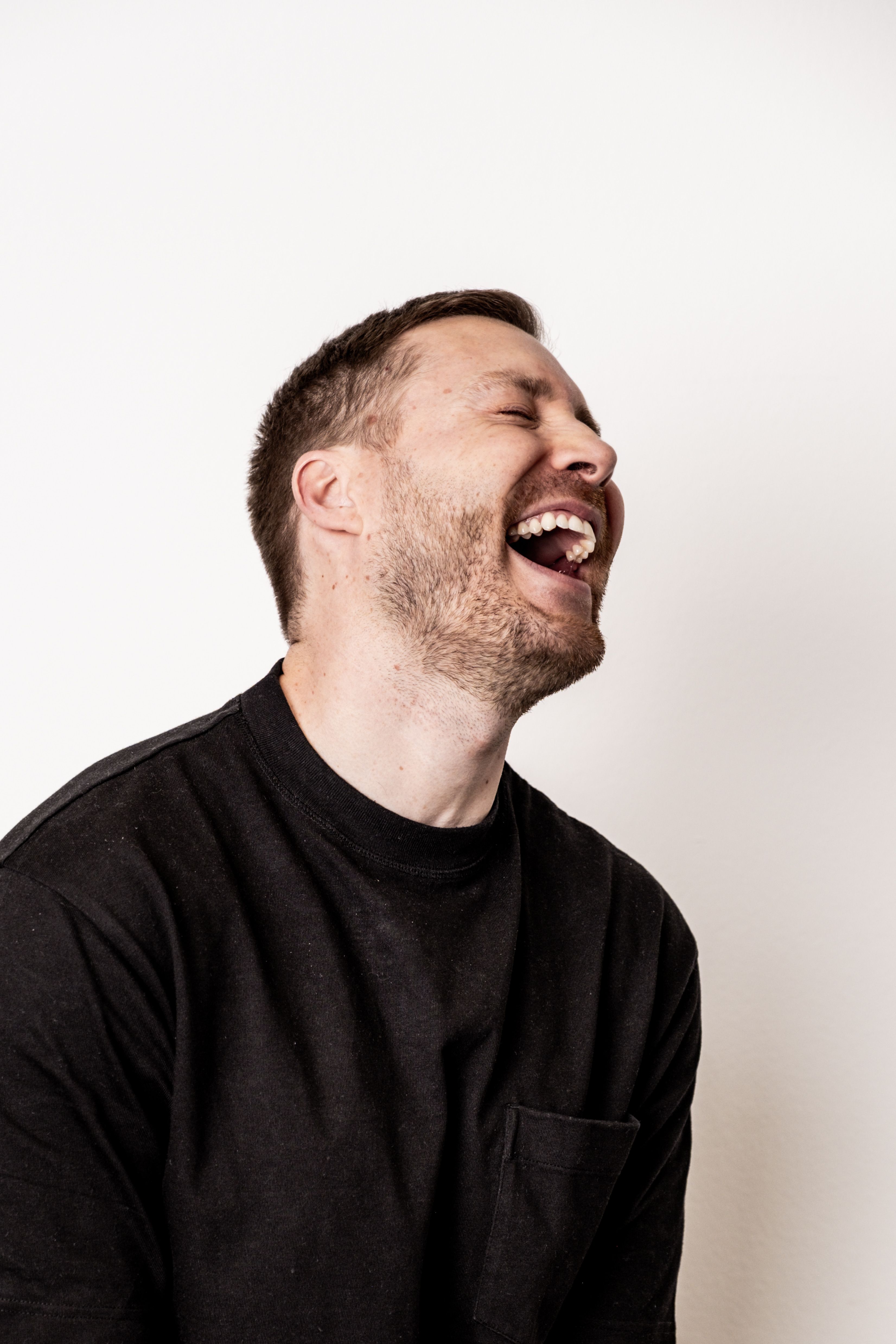 Joyful Adult Man Laughing in Studio Portrait · Free Stock Photo