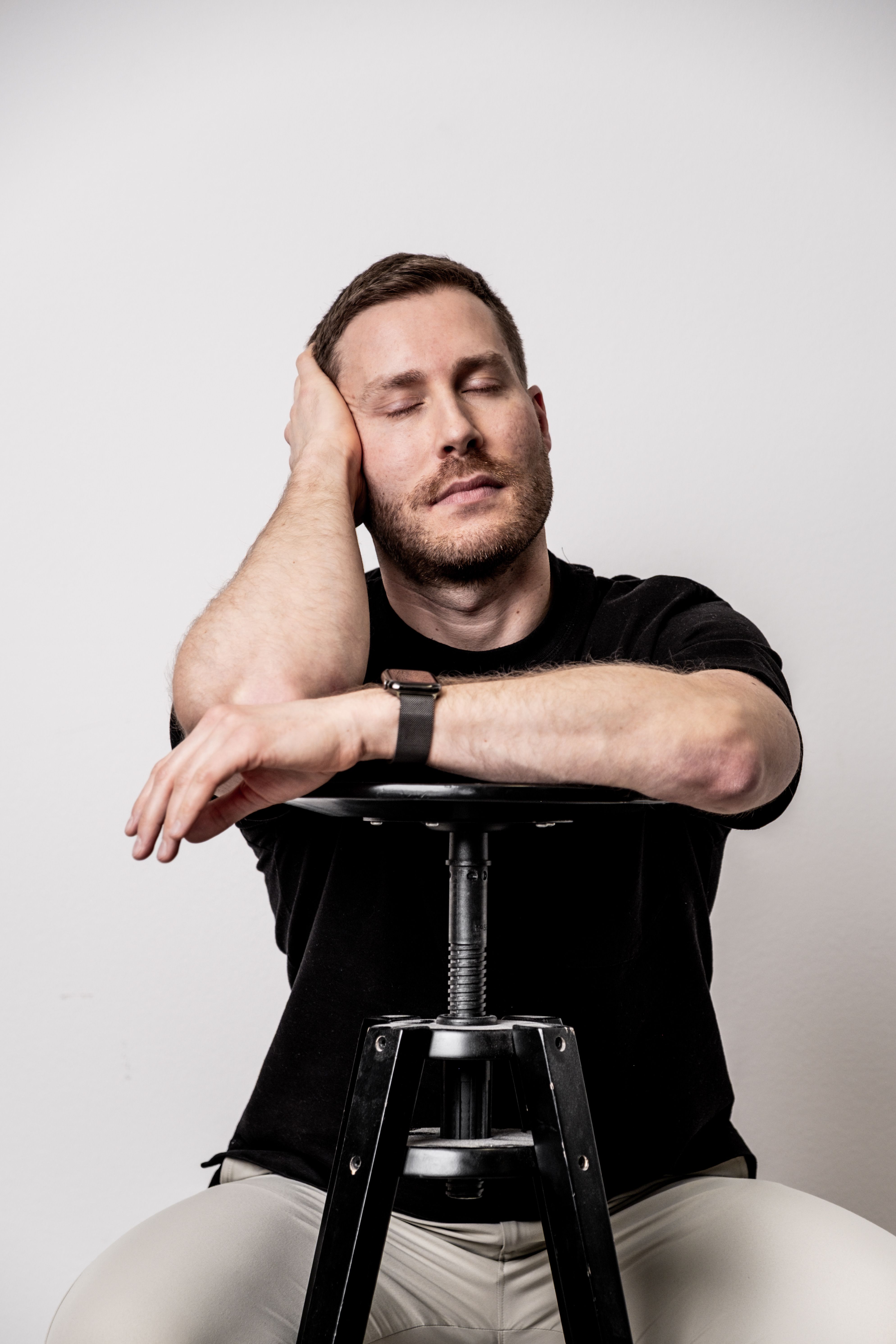 Tired Man Resting on Chair in Modern Setting · Free Stock Photo
