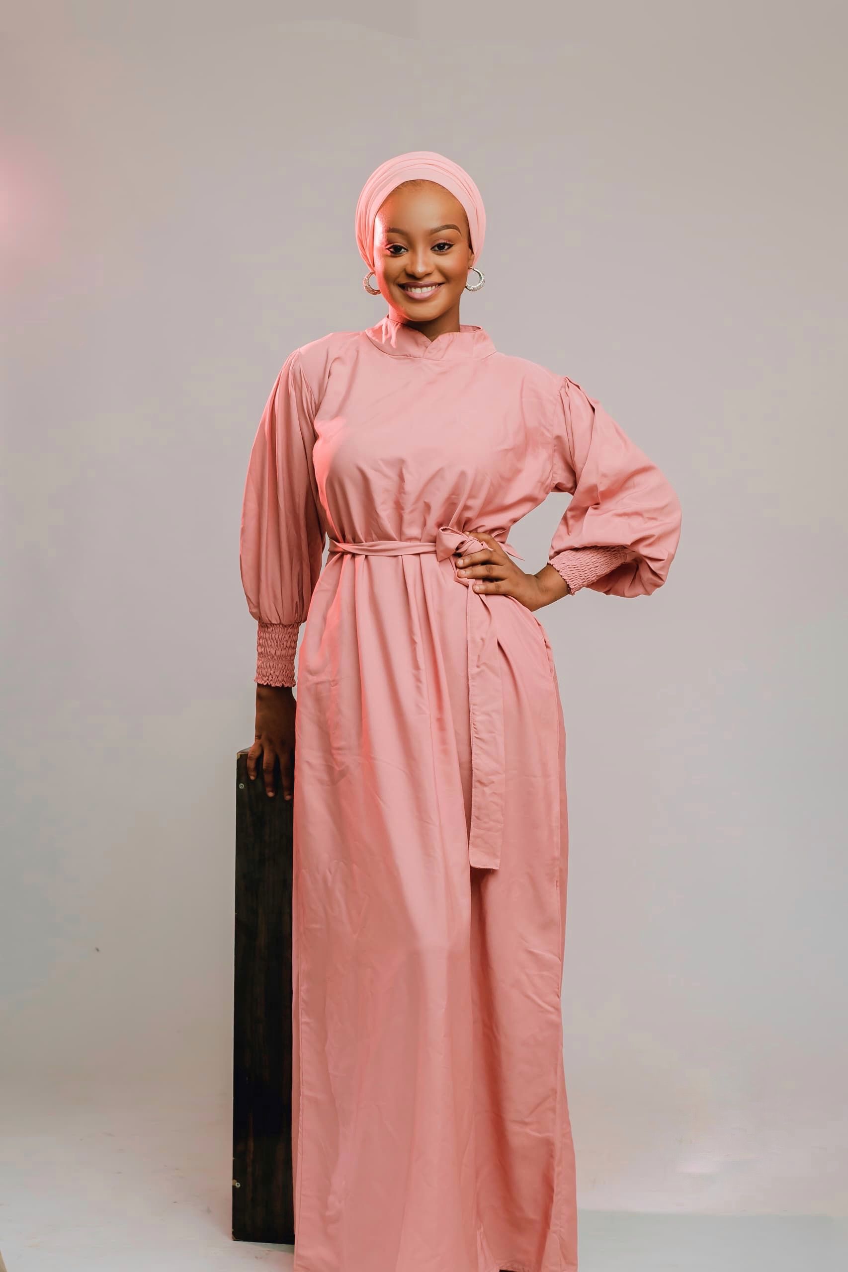Elegant woman in pastel pink dress posing confidently · Free Stock Photo