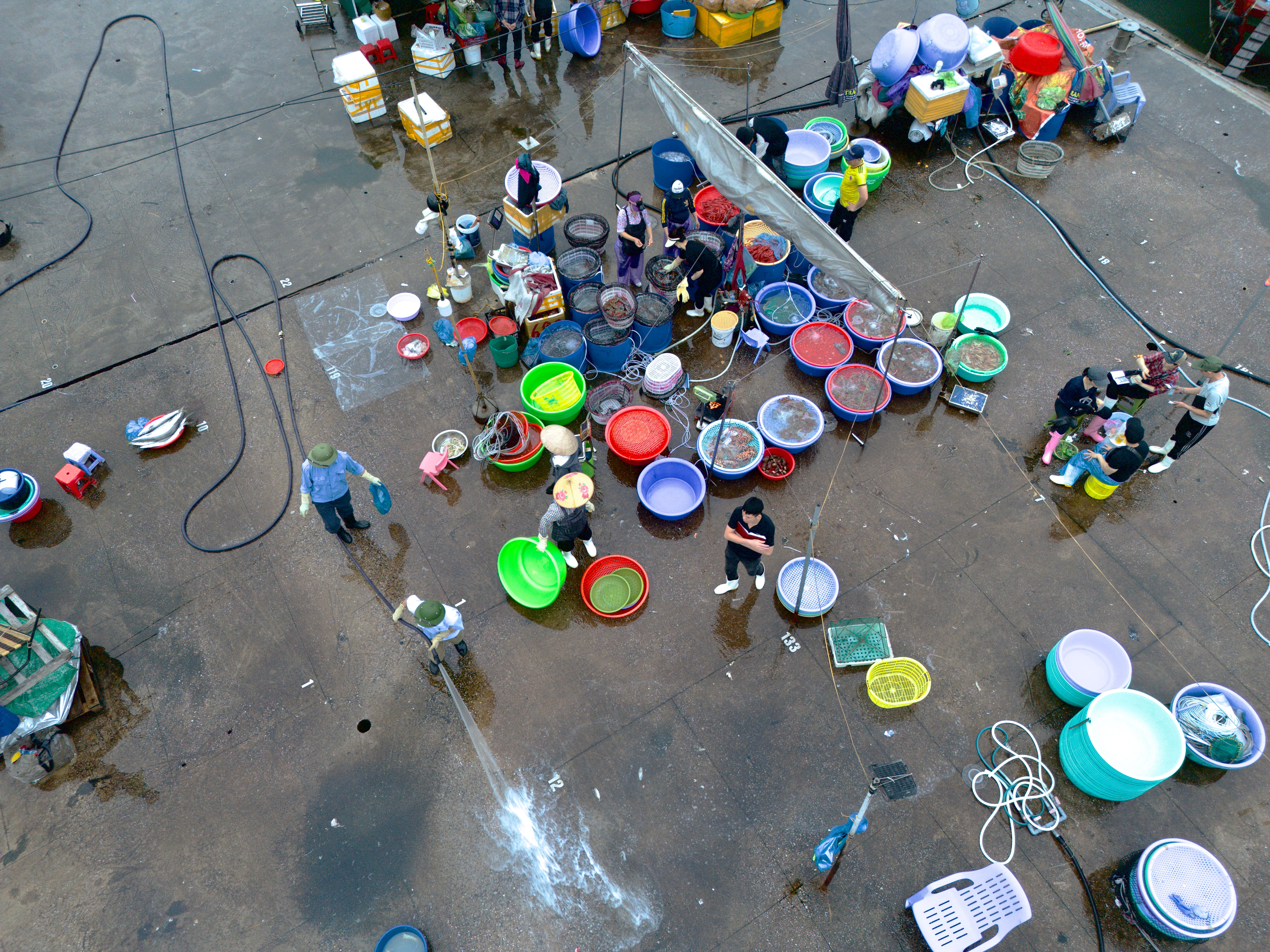 Aerial View of Colorful Market Buckets on Wet Pavement · Free Stock Photo