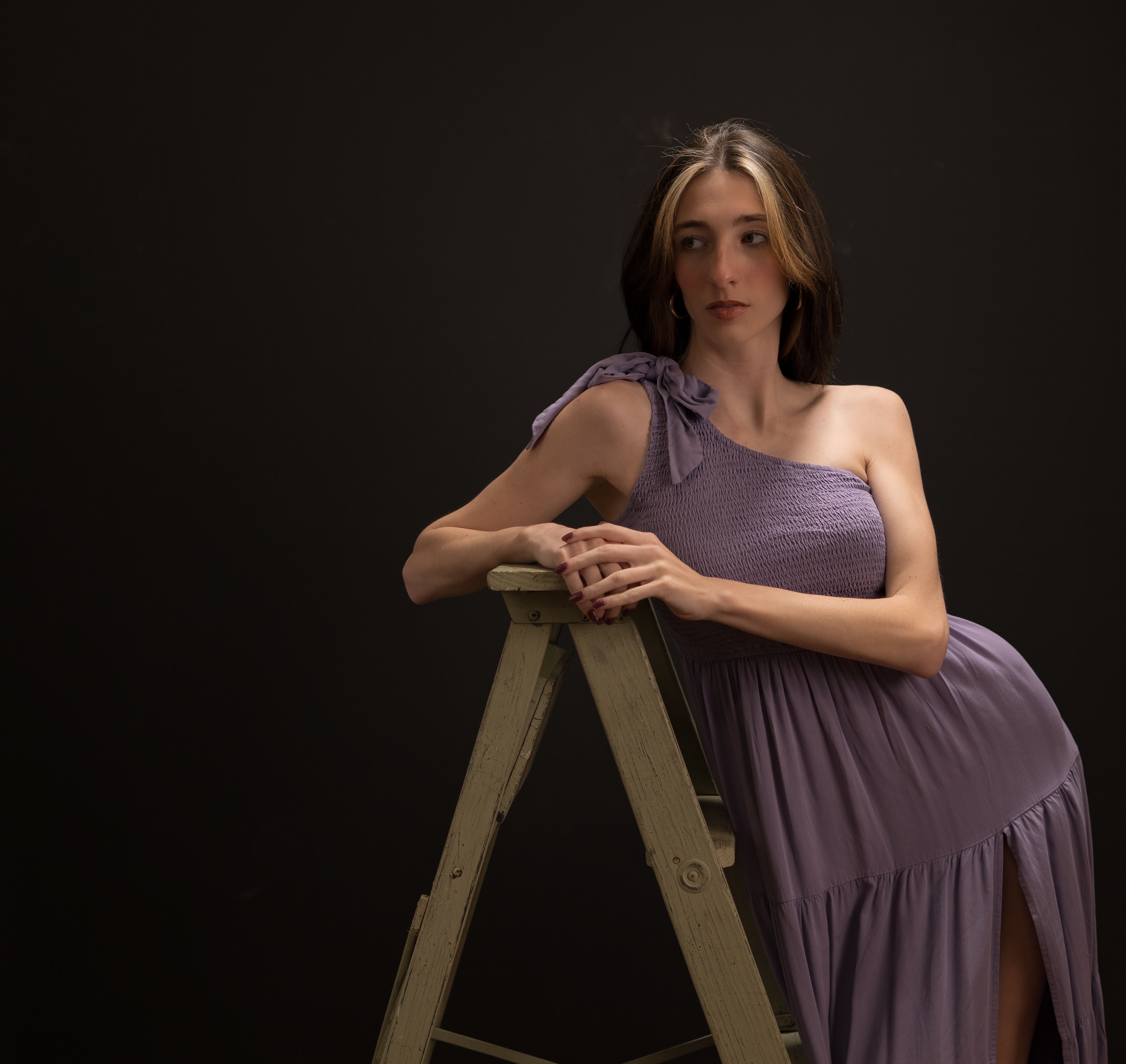 Elegant Woman in Lavender Dress Leaning on Ladder · Free Stock Photo