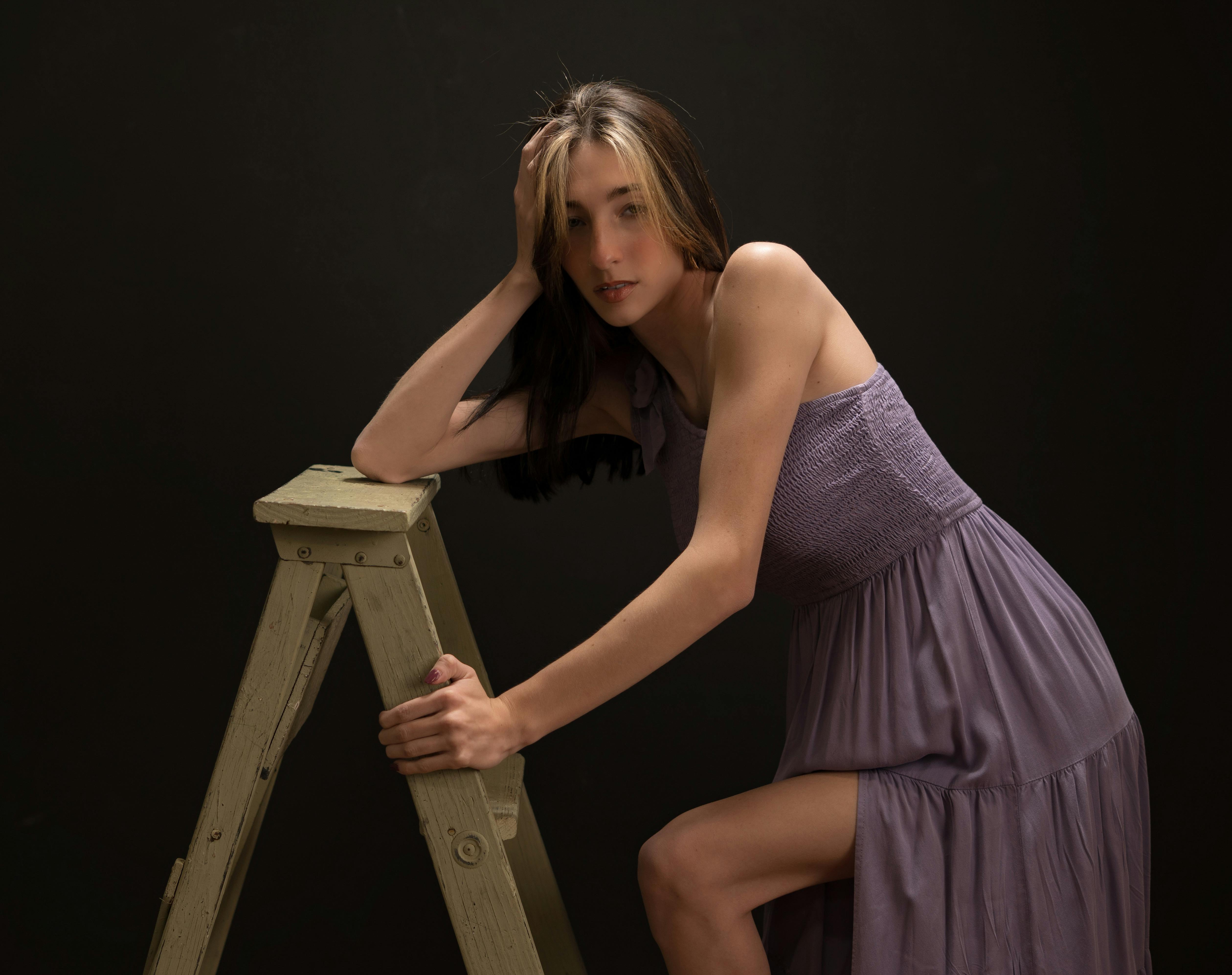Elegant Portrait of Woman in Lilac Dress on Ladder · Free Stock Photo