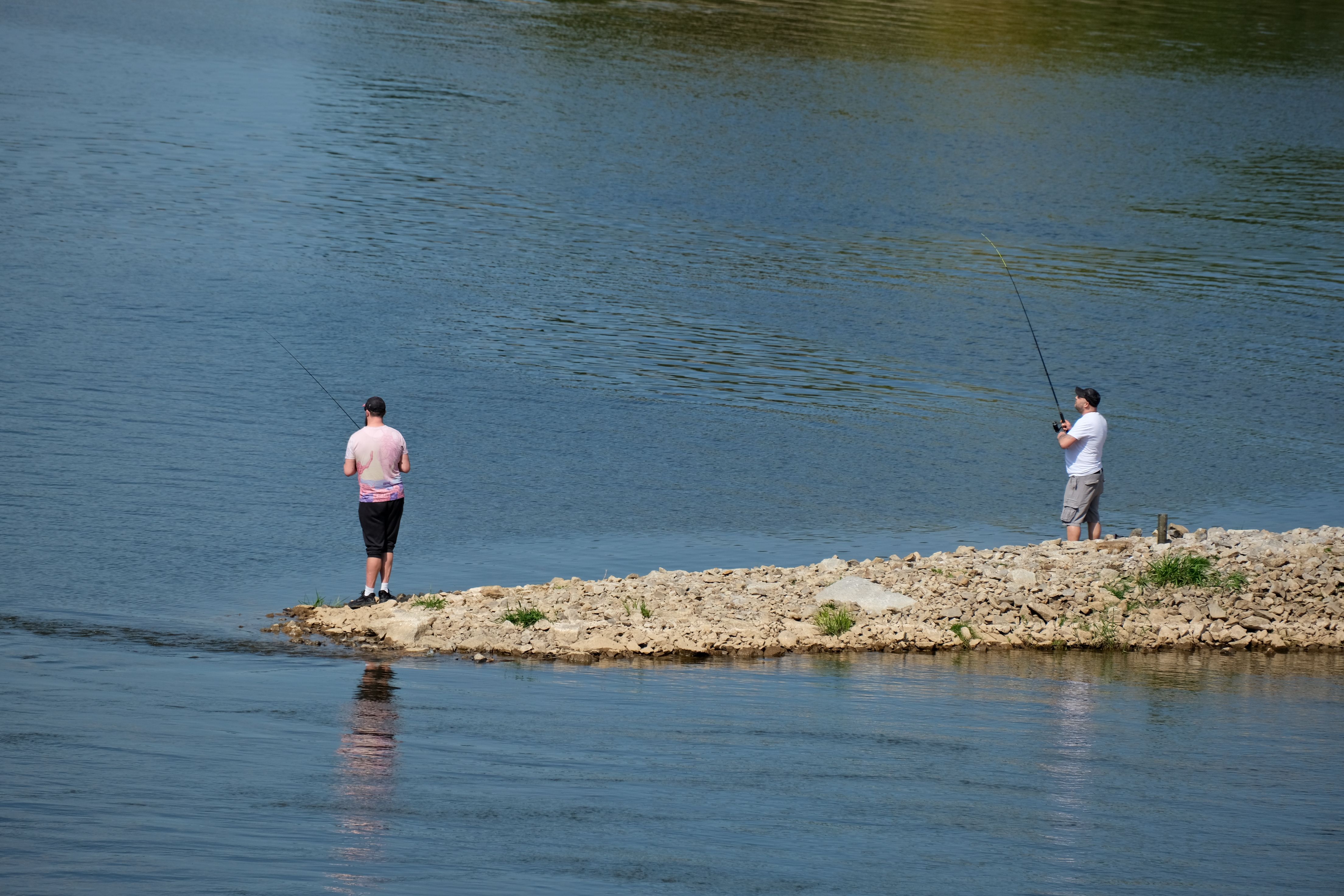 Two Men Fishing by a Calm Lakeside · Free Stock Photo
