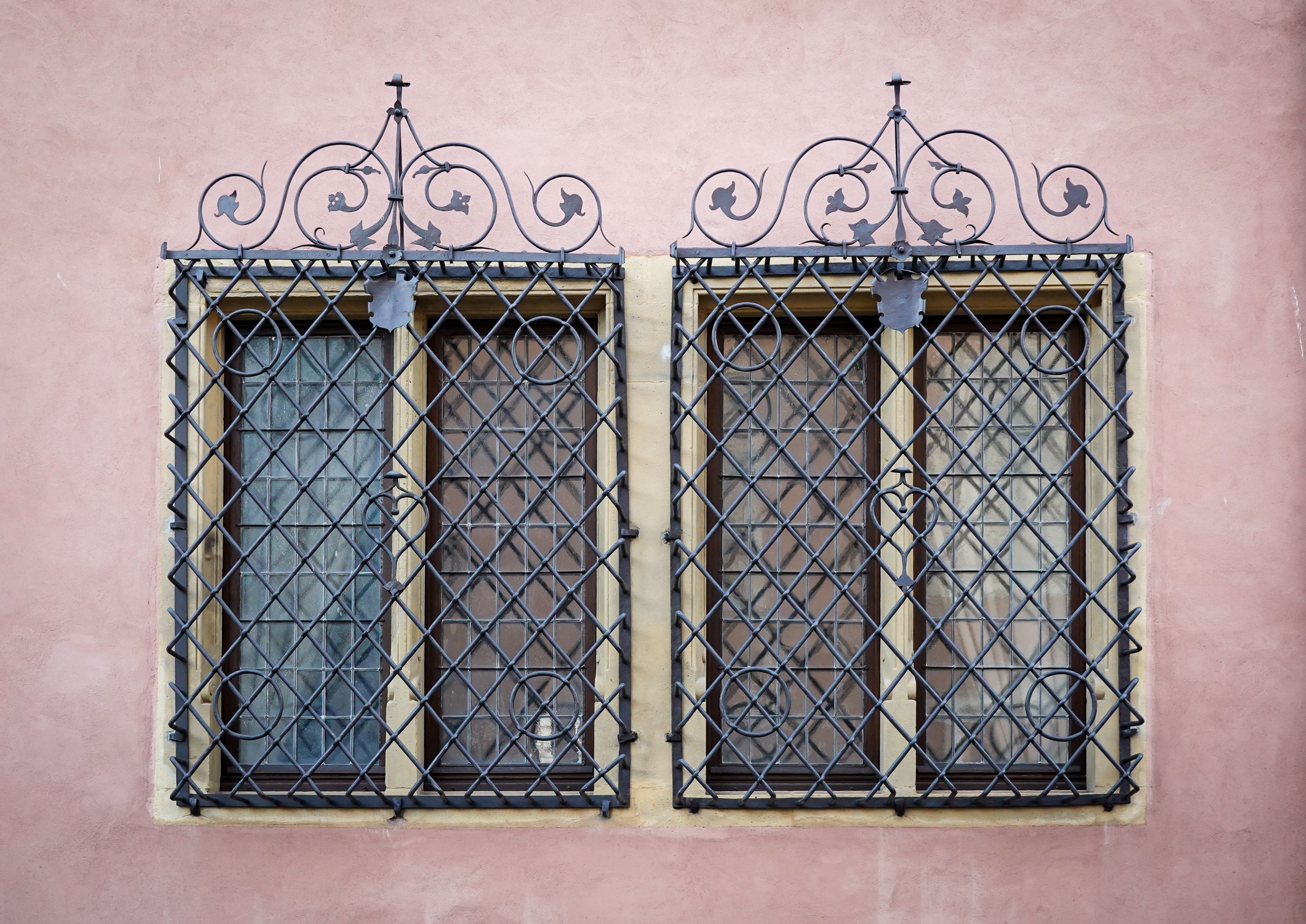 Ornate Iron Lattice on Historic Windows · Free Stock Photo