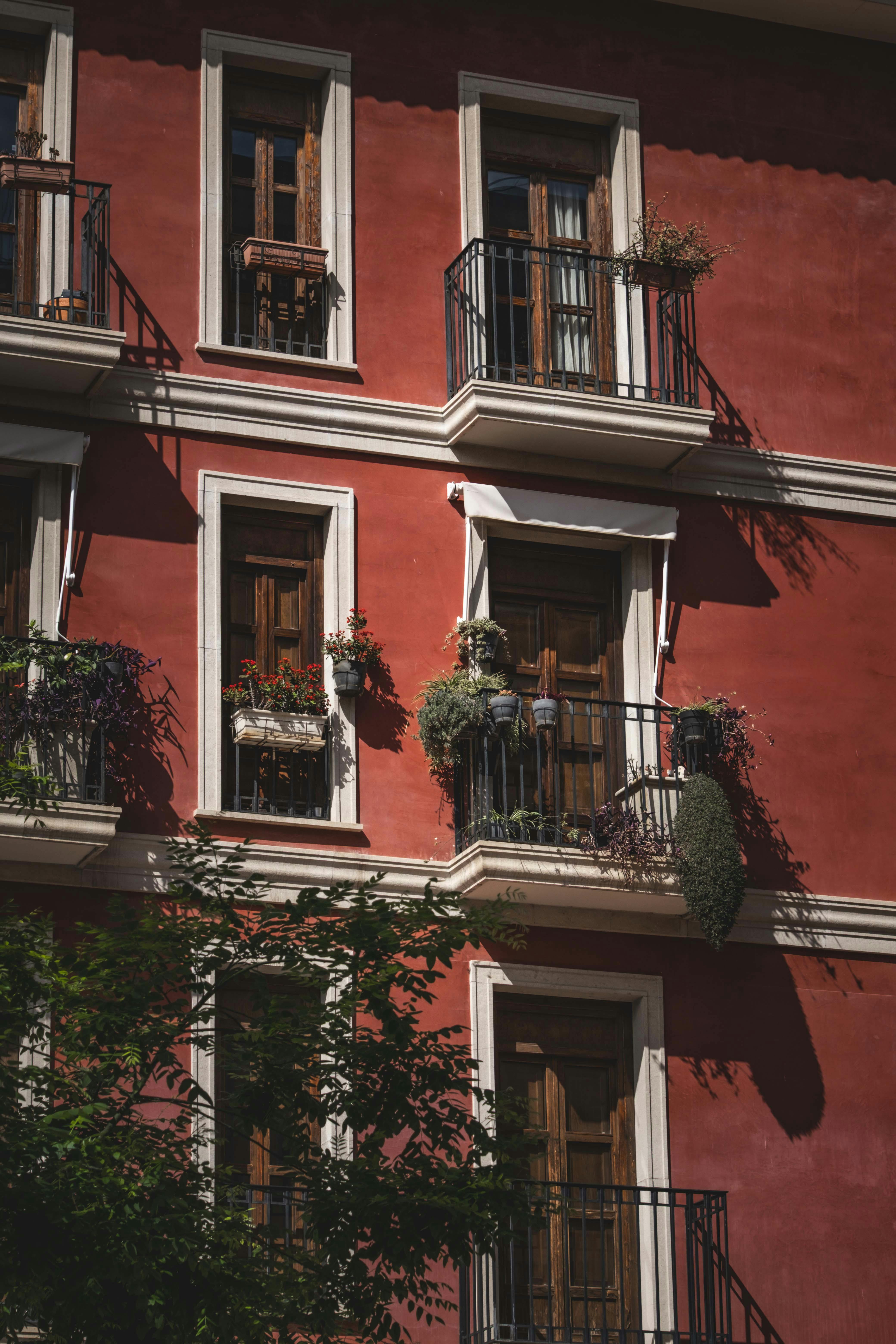 Charming Red Facade with Rustic Balconies · Free Stock Photo
