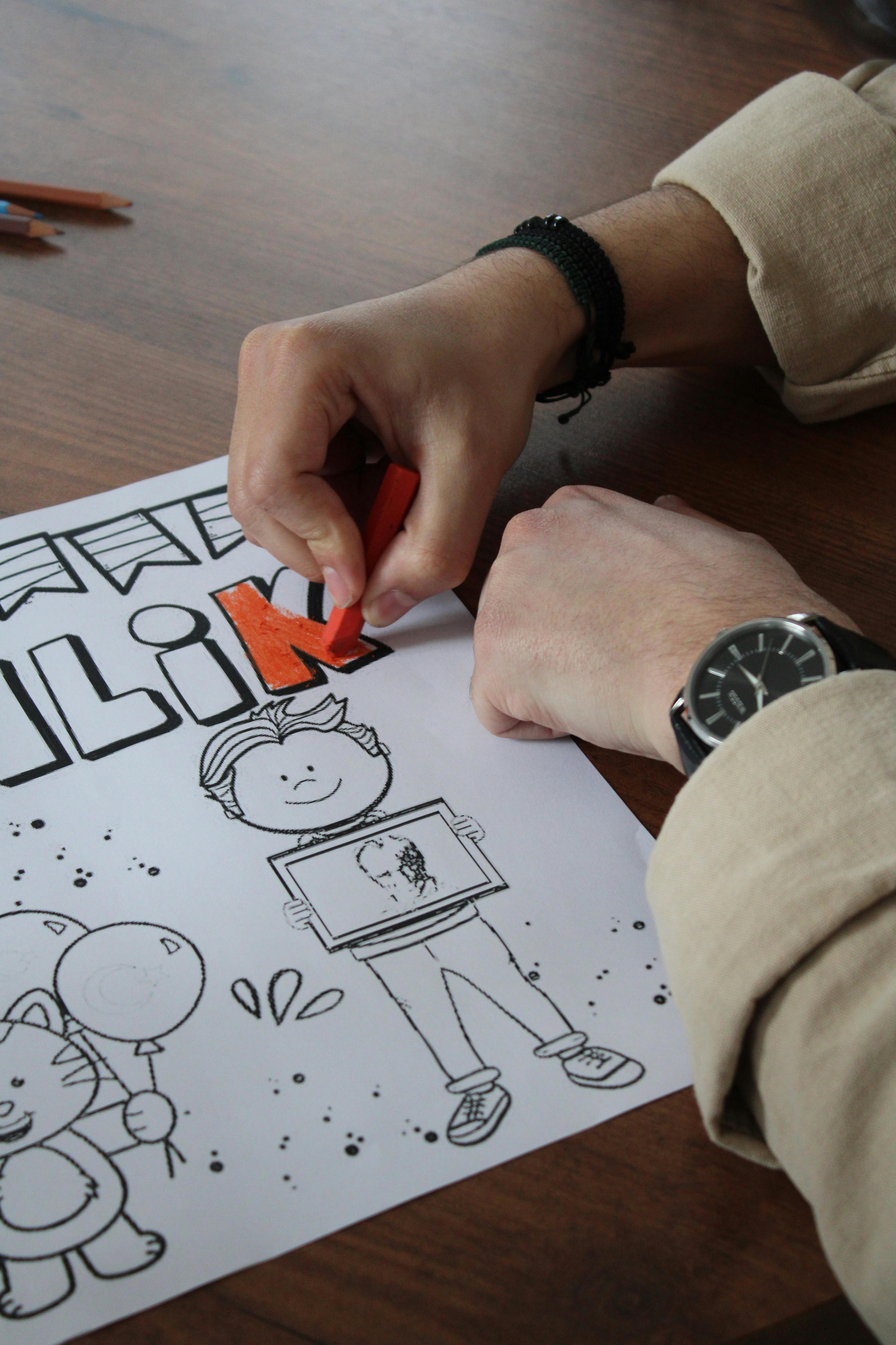 Close-up of Hand Coloring Drawing on Table · Free Stock Photo