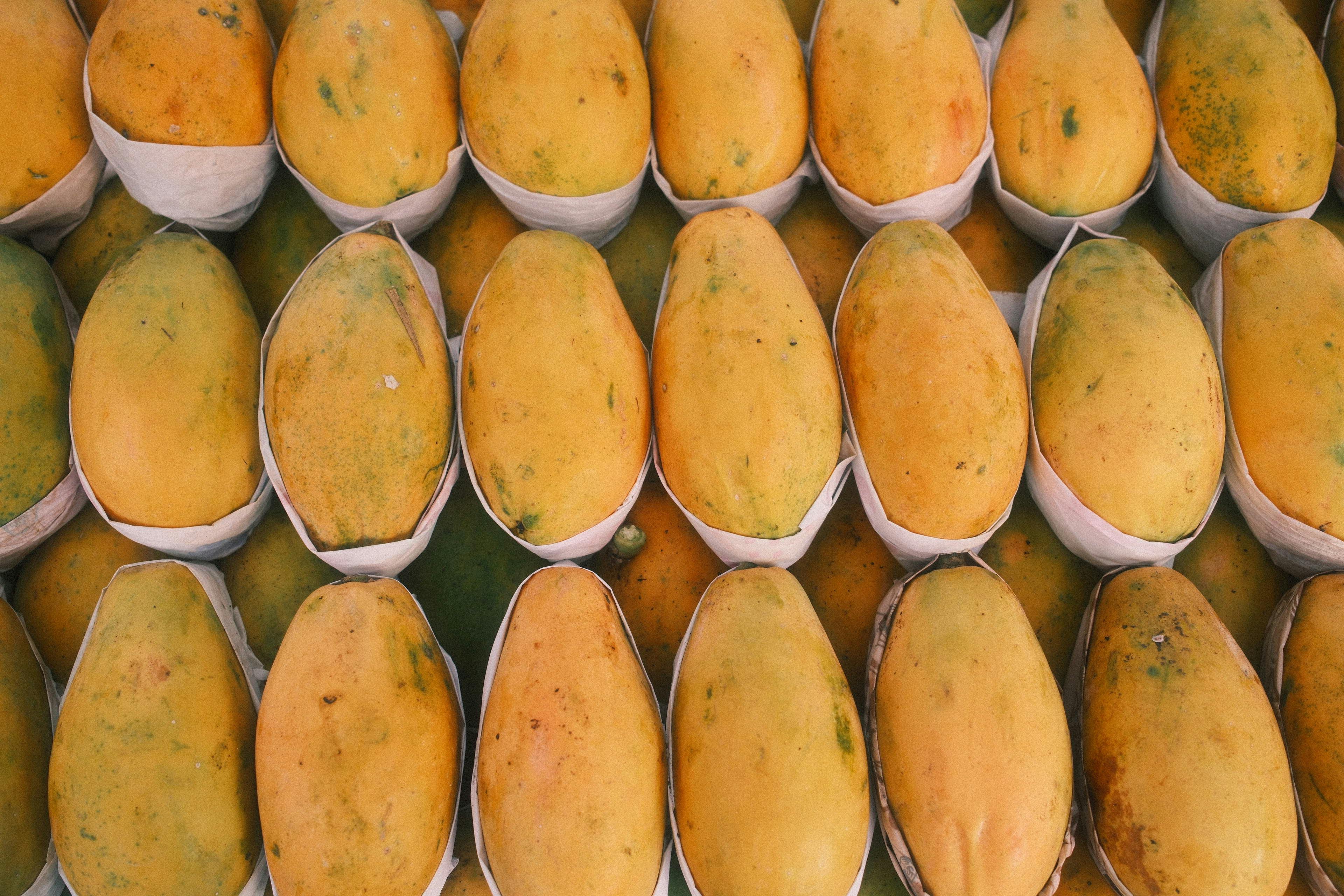 Fresh Yellow Mangoes Displayed on Market Stand · Free Stock Photo