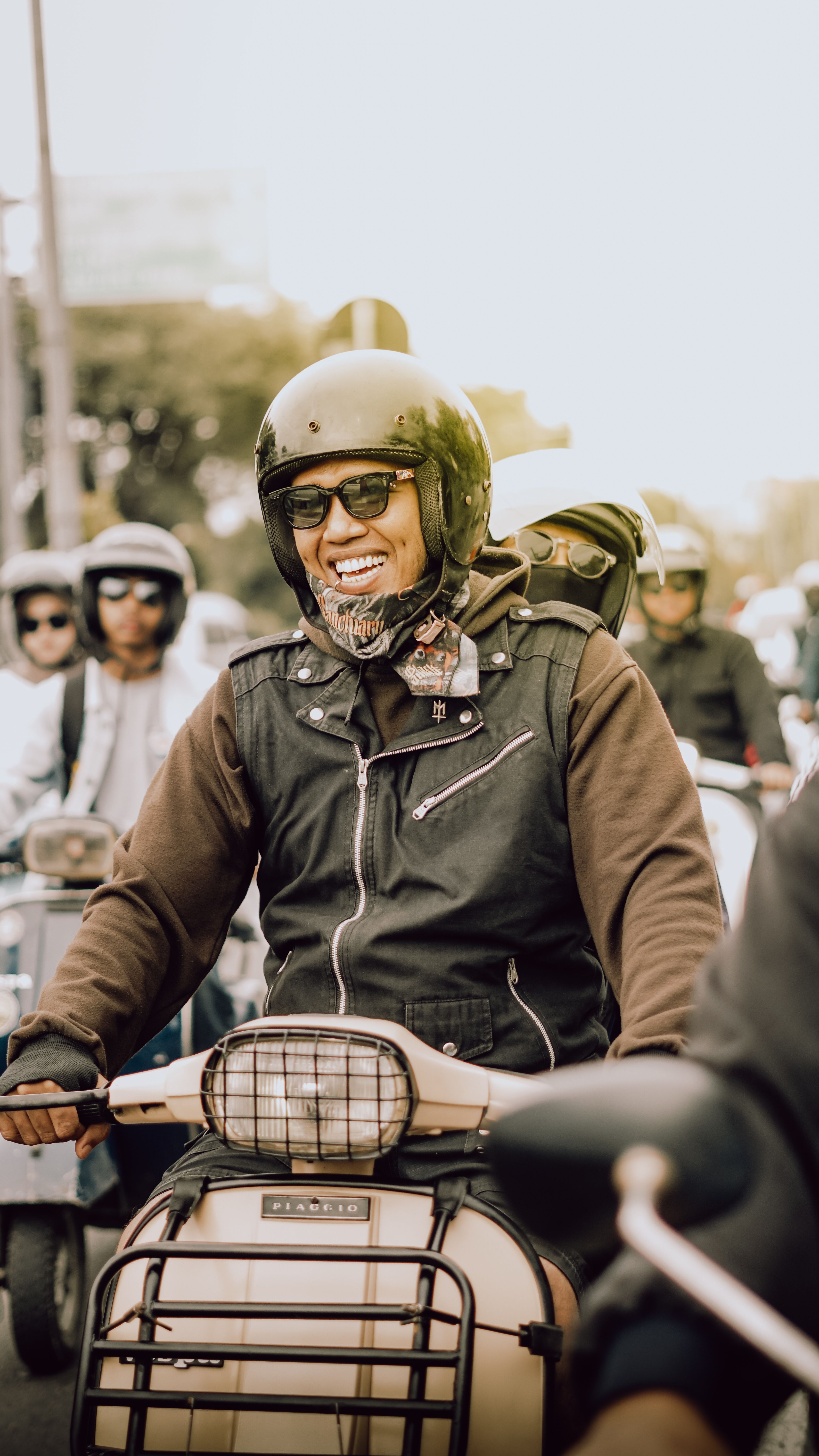 Smiling Motorcyclist Riding Vespa in City Street · Free Stock Photo