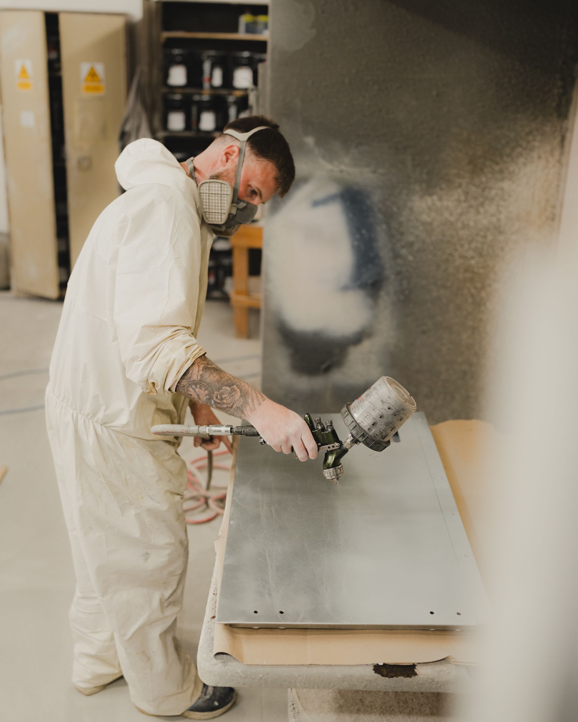 Man in Protective Gear Painting Metal Panel · Free Stock Photo