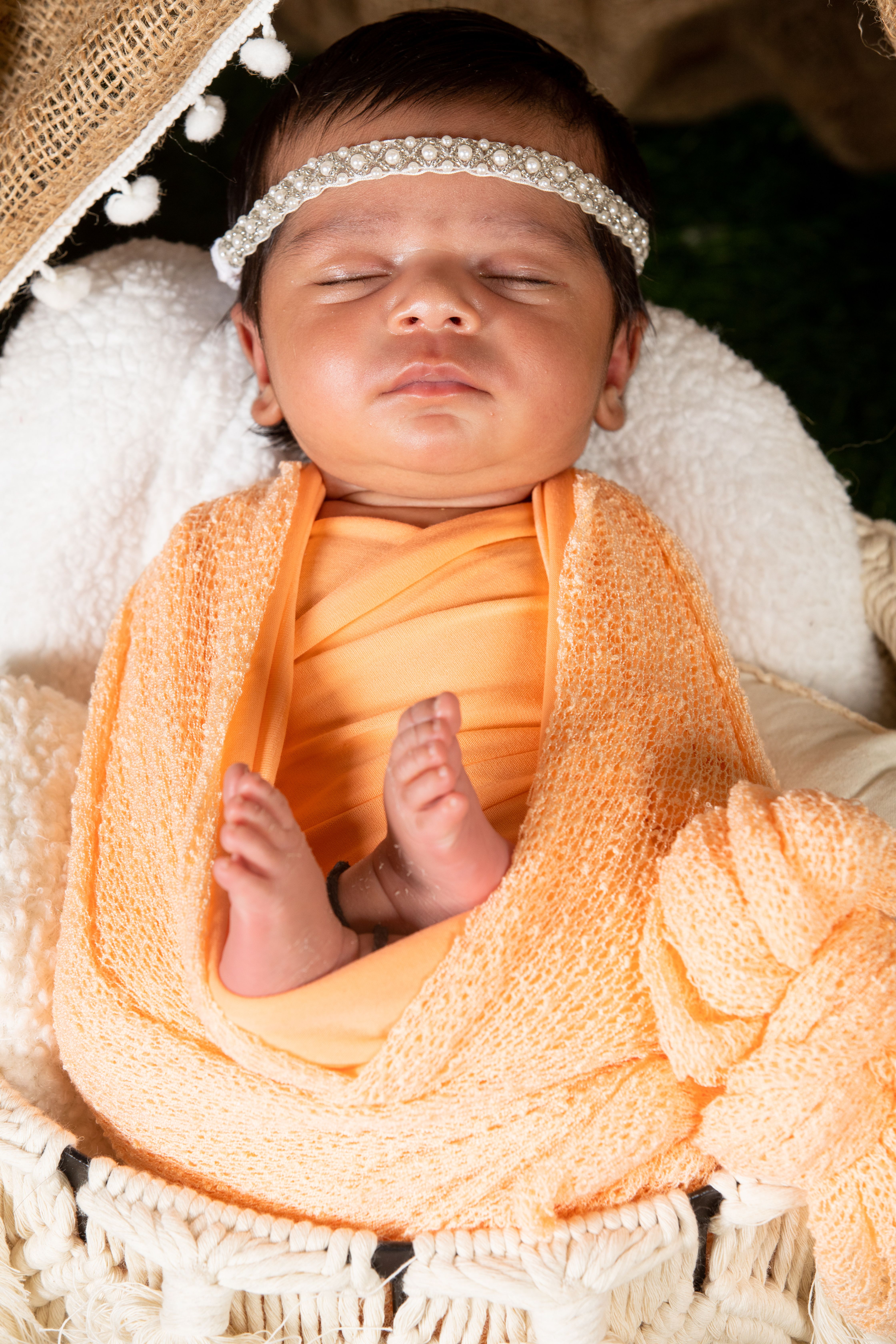 Peaceful Newborn Baby in Orange Wrap · Free Stock Photo
