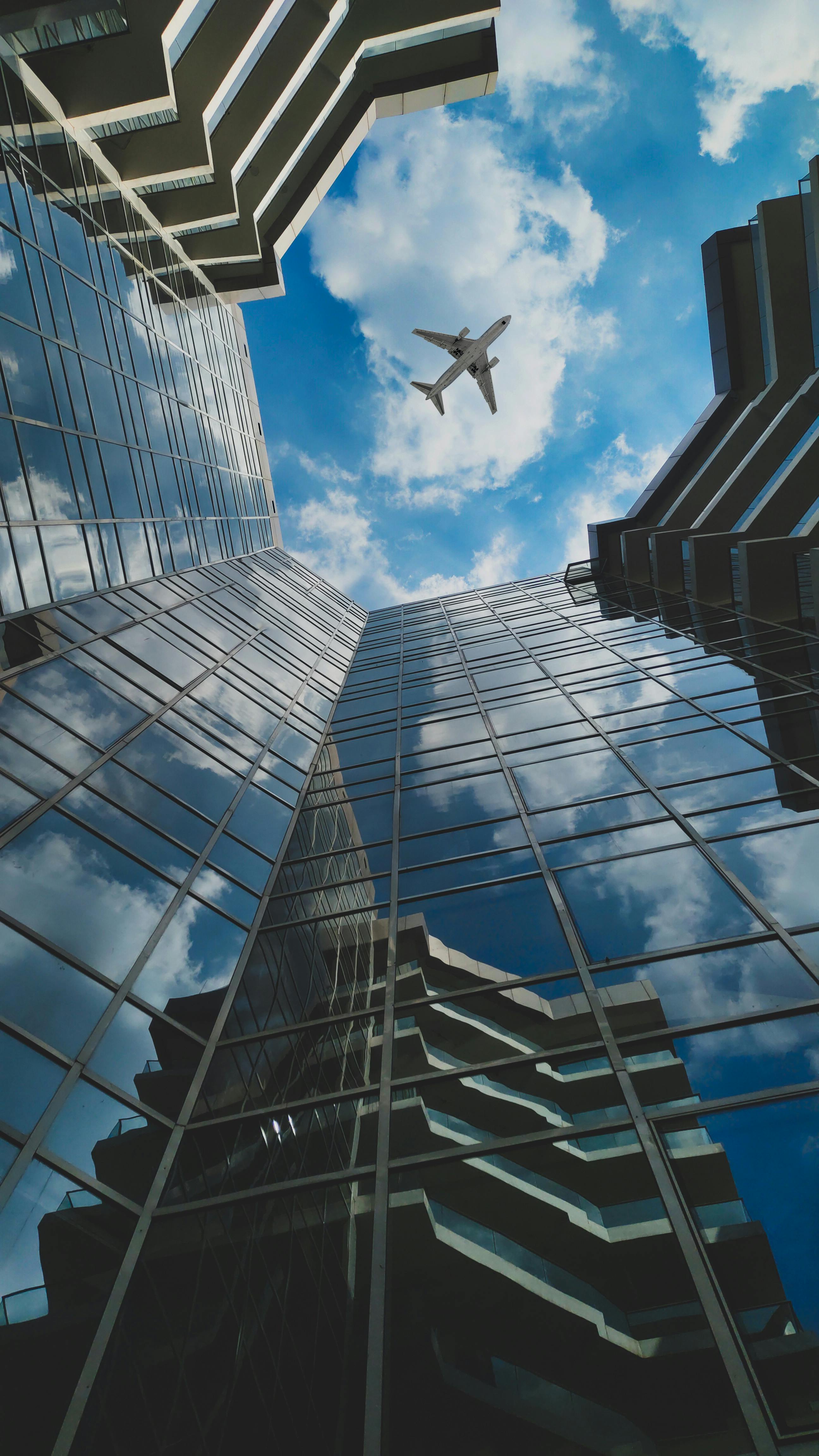 Airplane Near Blue and Grey Building · Free Stock Photo