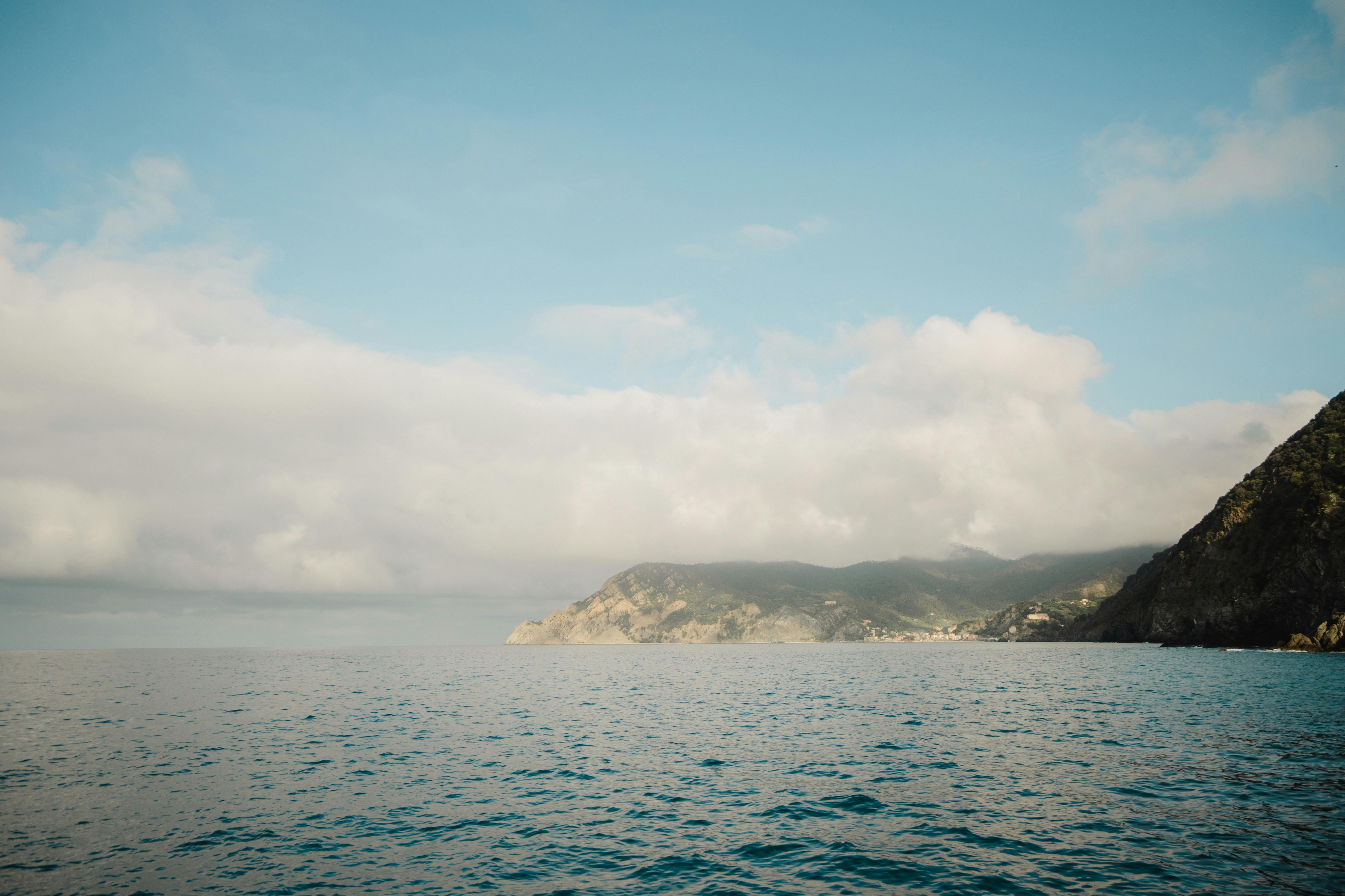 Expansive Sea View of Rugged Coast with Blue Sky · Free Stock Photo