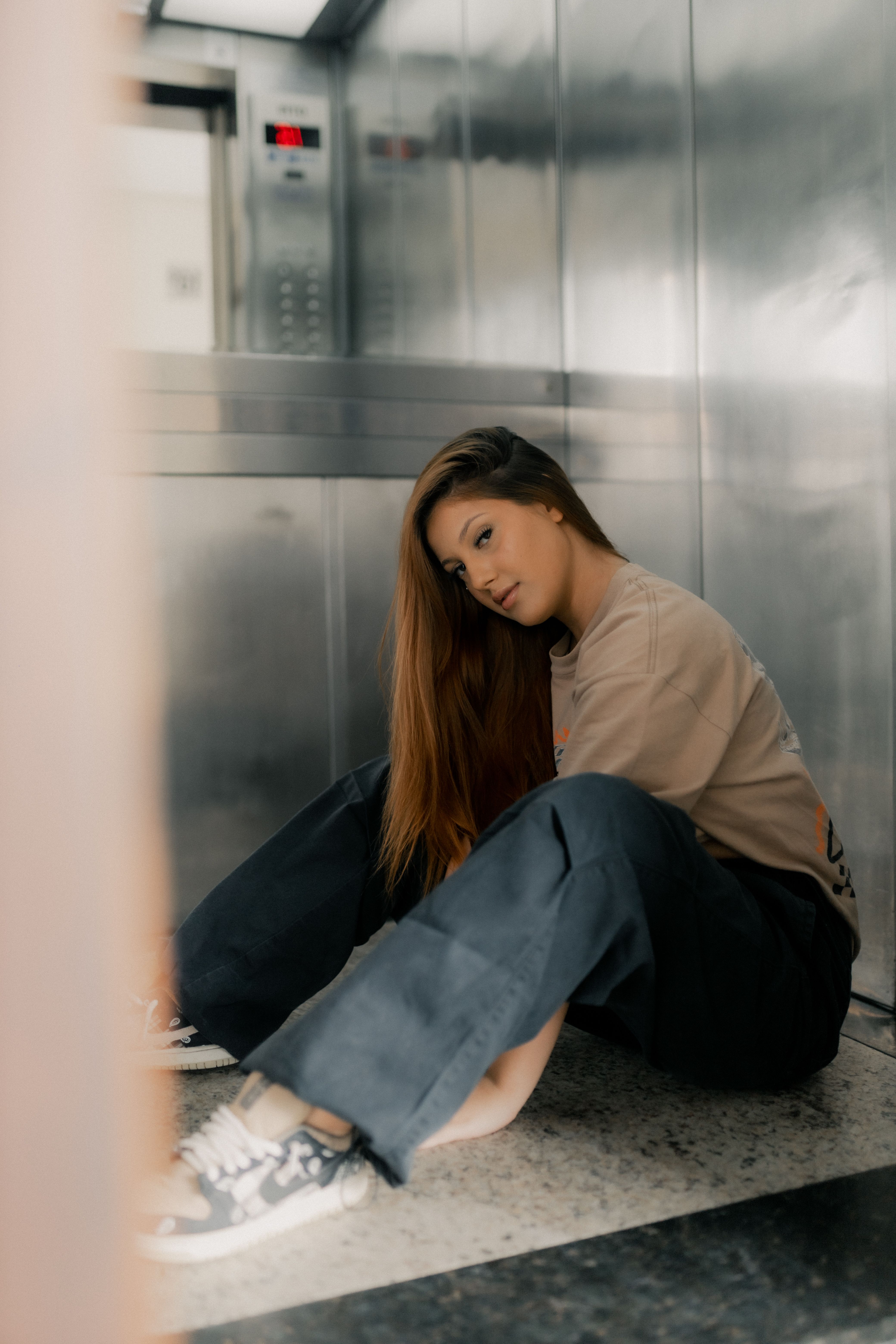 Pensive Woman Sitting in Modern Elevator · Free Stock Photo