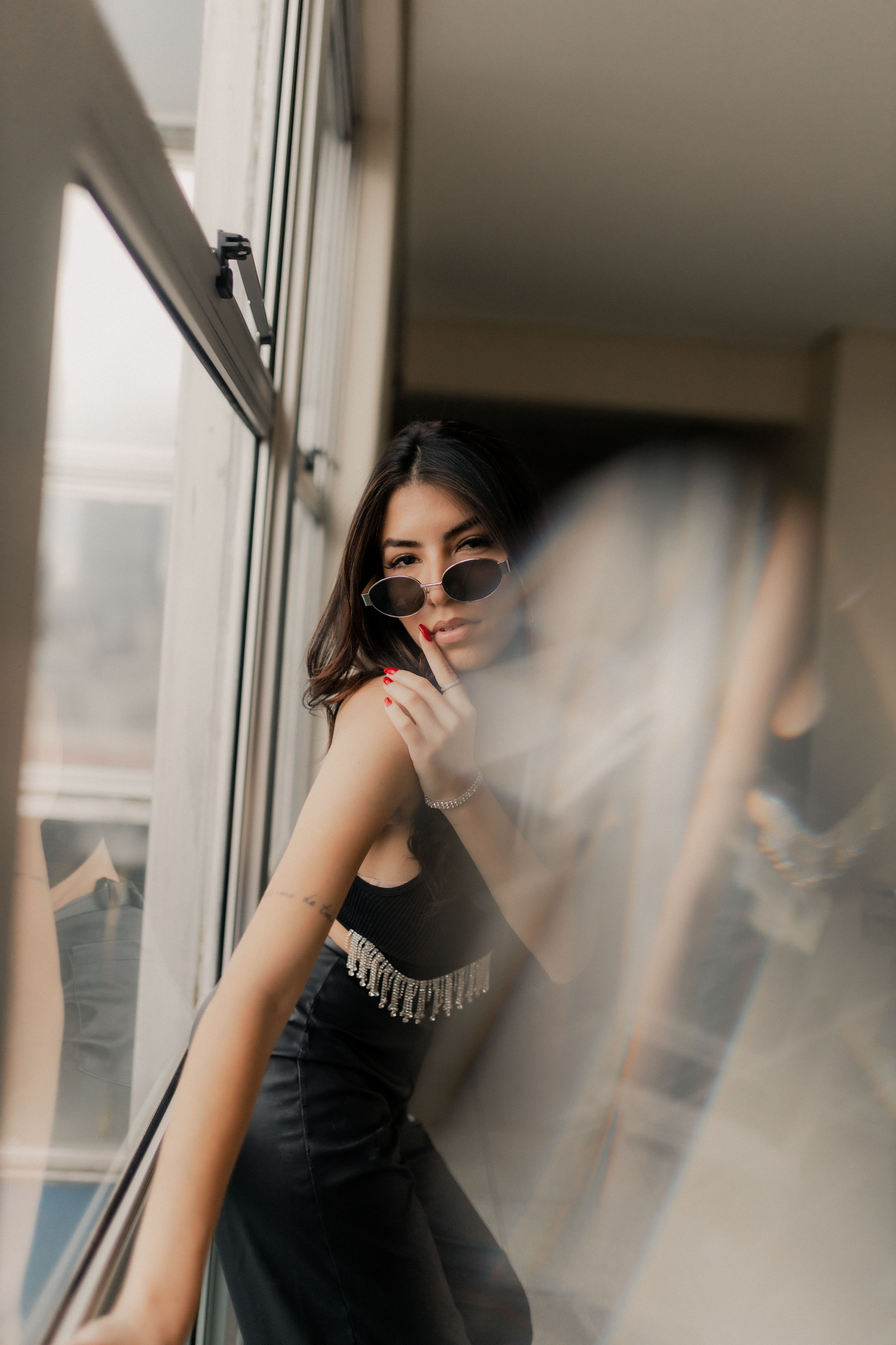 Stylish Woman Posing by Window in Sunglasses · Free Stock Photo