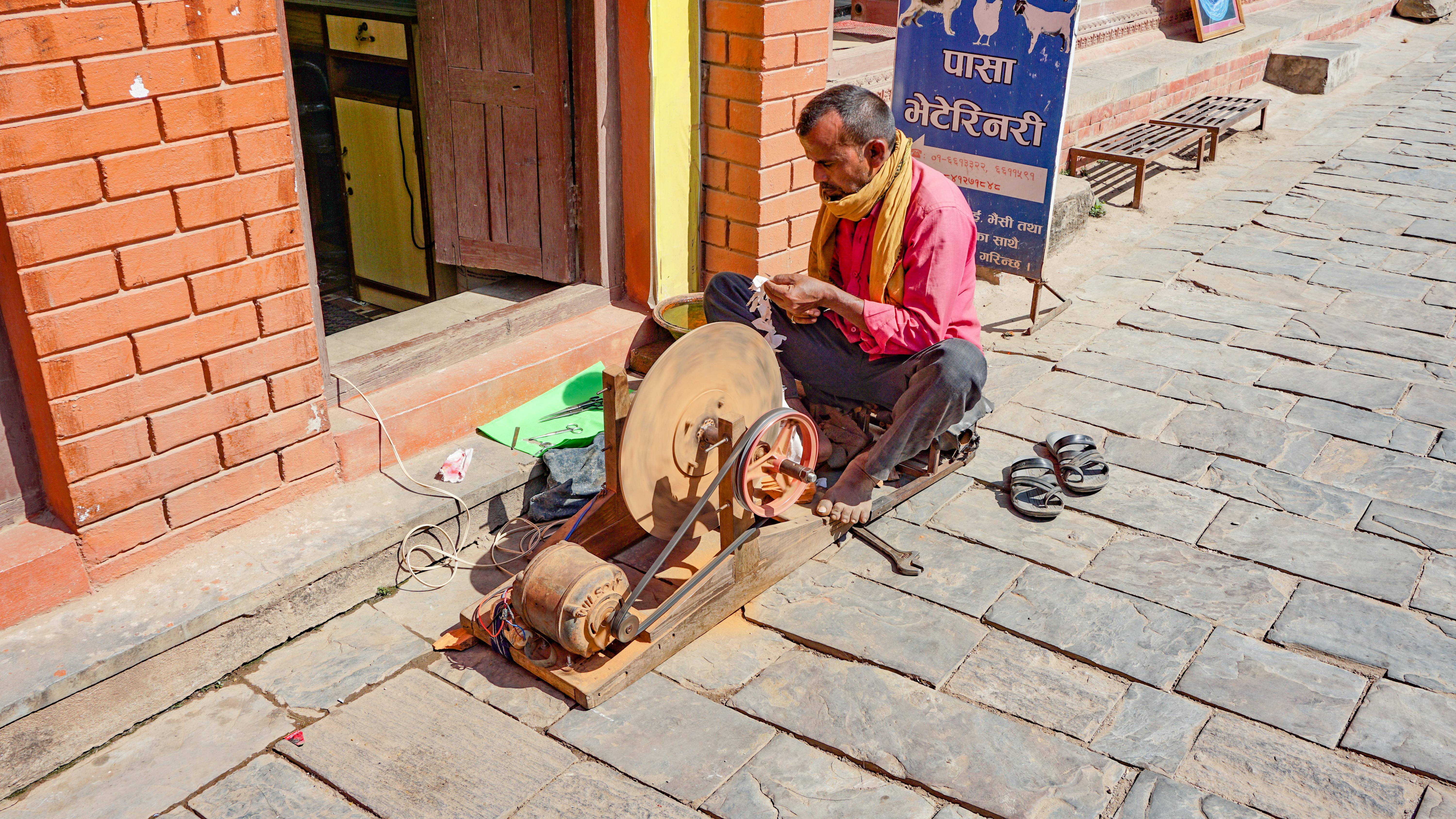Street Cobbler Working on Old Grinding Machine · Free Stock Photo