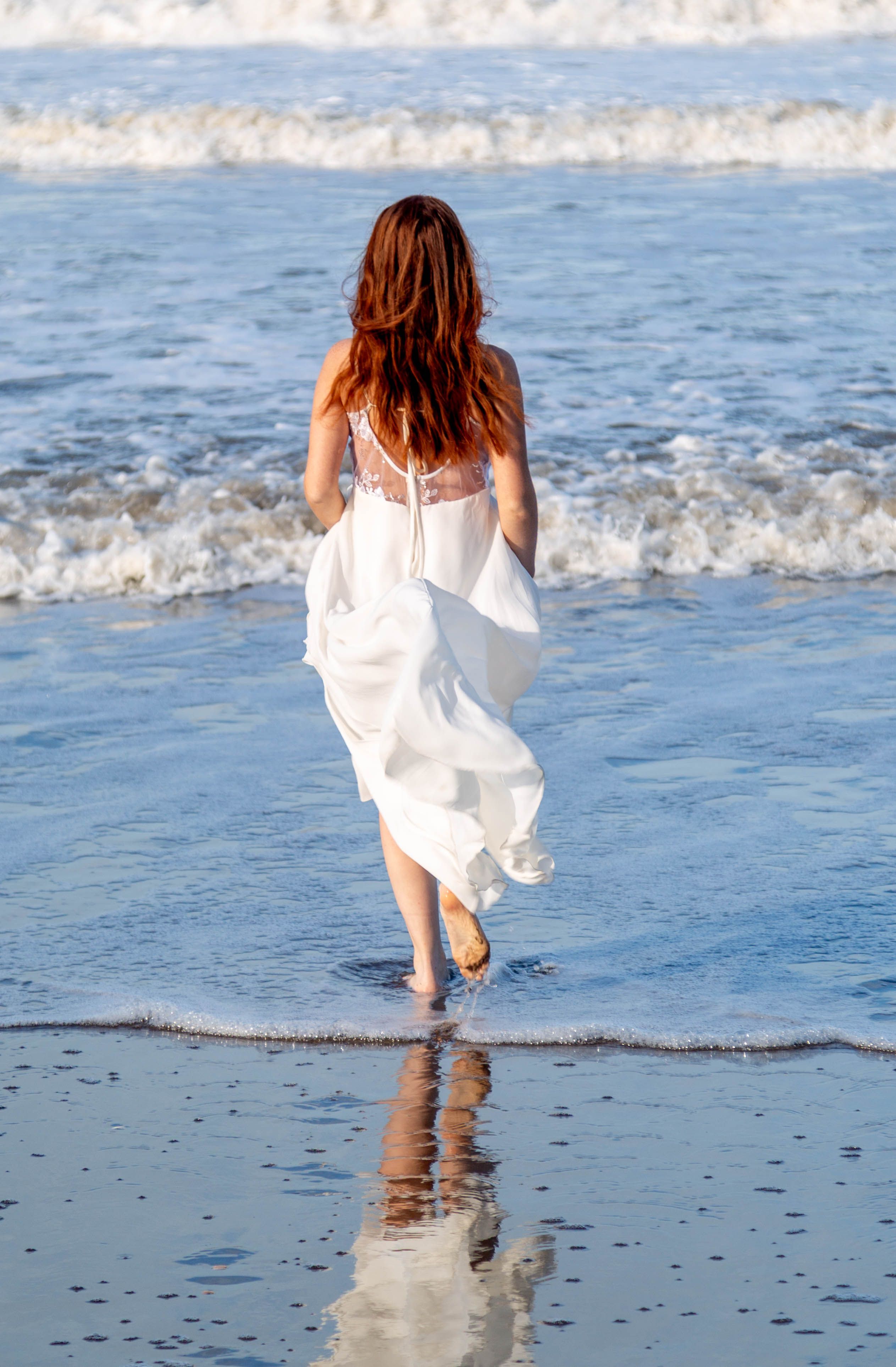Elegant Woman Walking Into the Ocean at Beach · Free Stock Photo