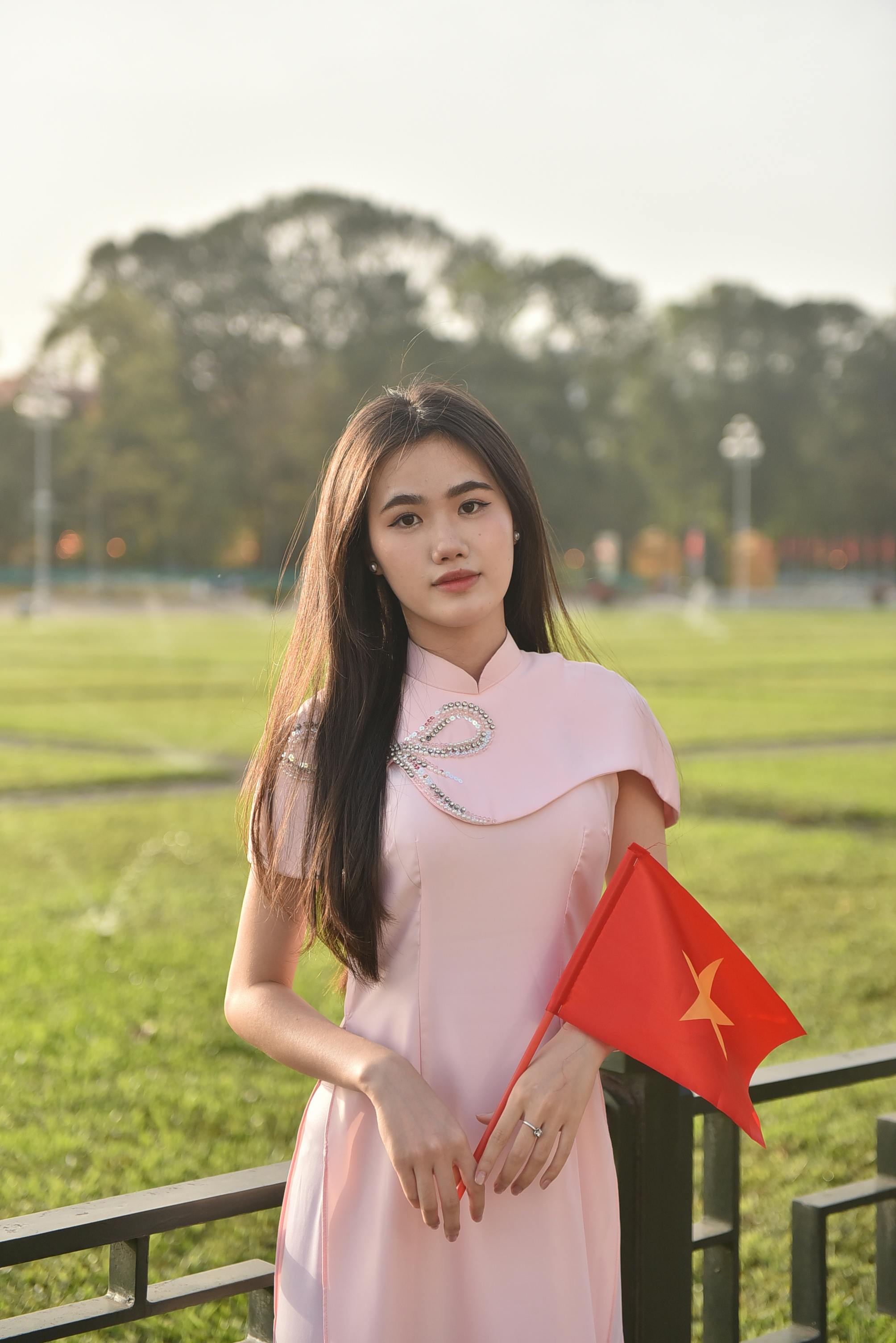 Young Woman in Pink Áo Dài Holding Vietnamese Flag · Free Stock Photo