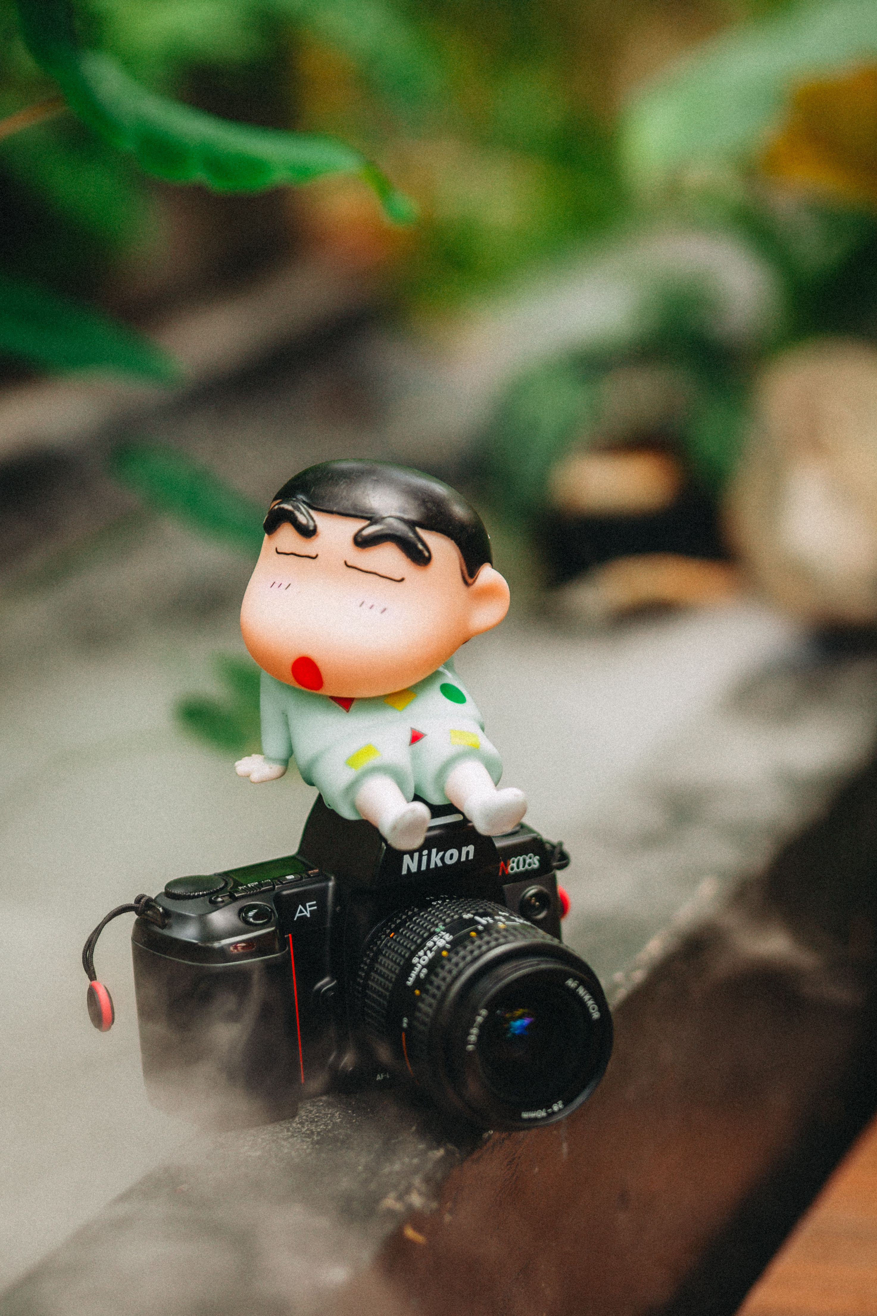 Cute Toy Figurine on DSLR Camera Outdoors · Free Stock Photo