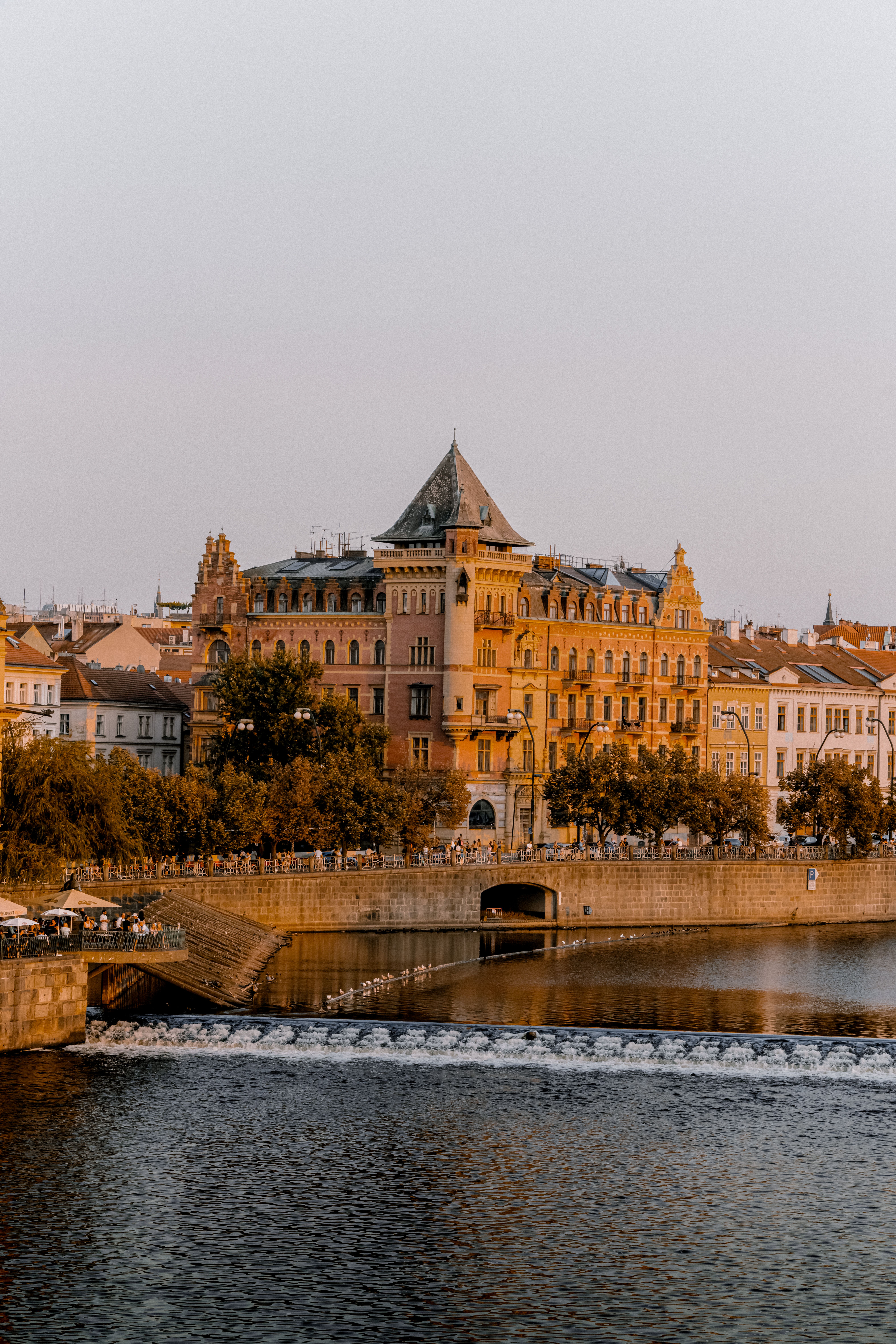 Historic European Building by Riverside at Sunset · Free Stock Photo