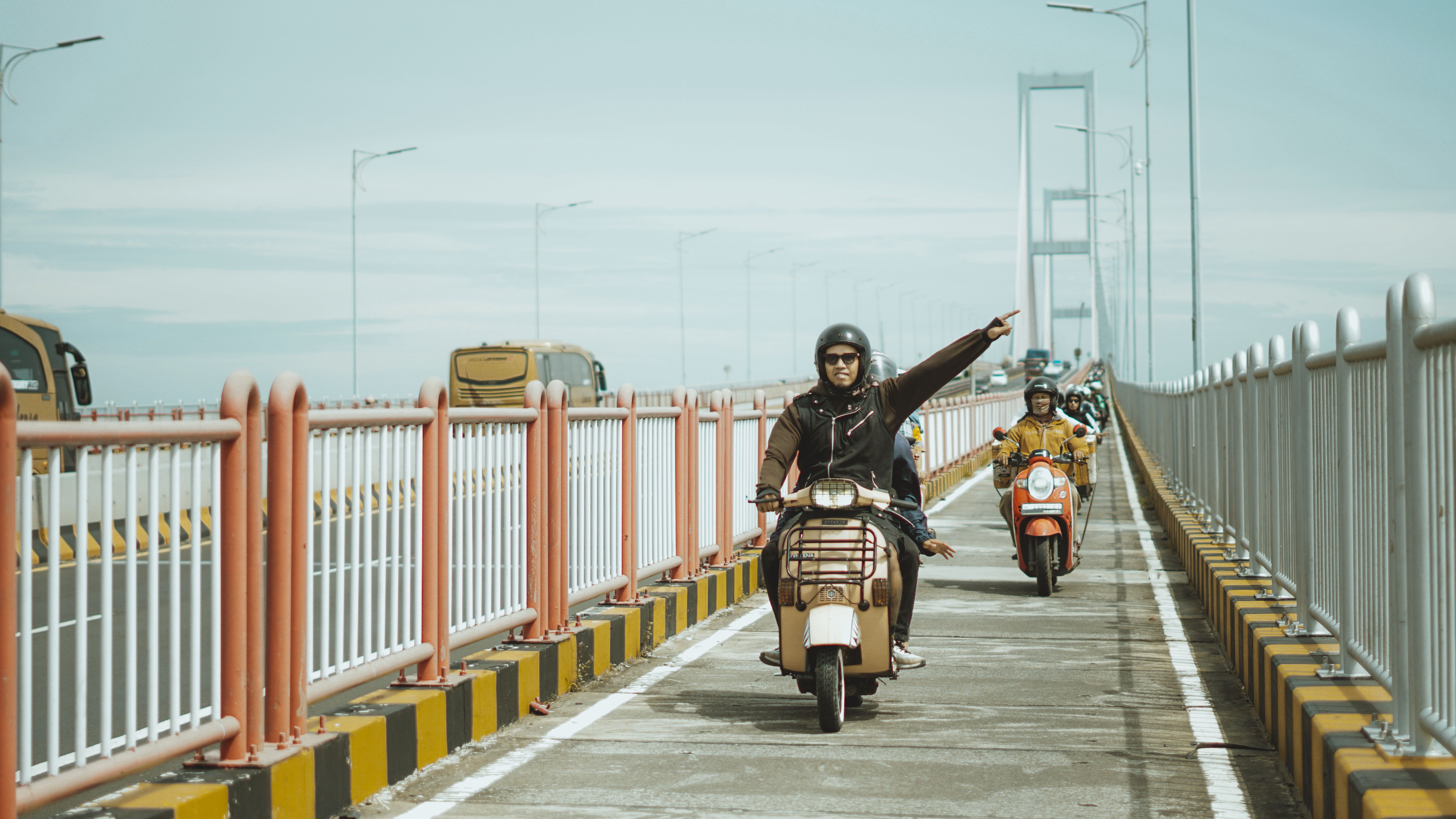 Group Riding Vespas Across Indonesian Bridge in Daylight · Free Stock Photo