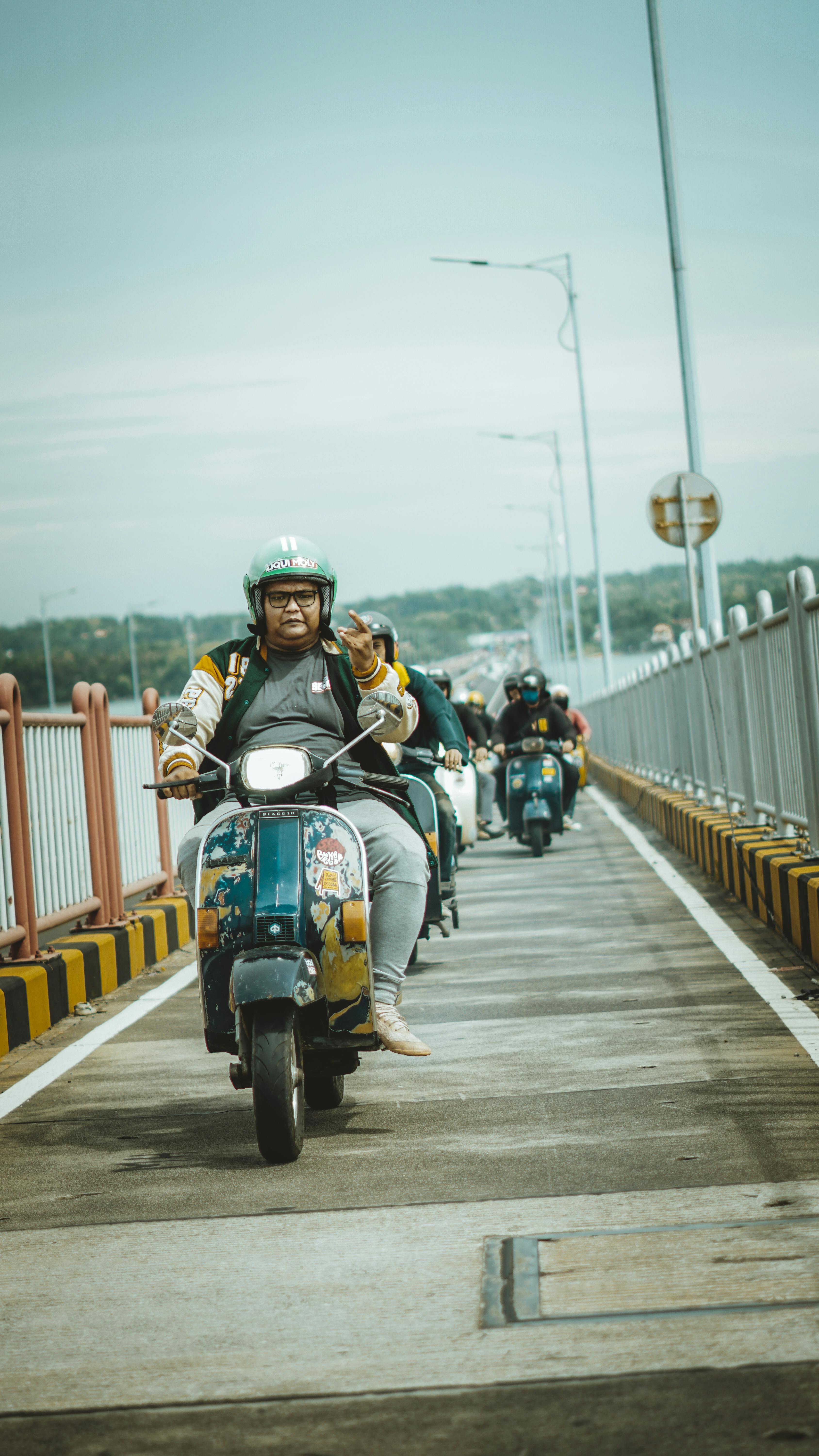 Group Riding Vespas on Indonesian Bridge · Free Stock Photo