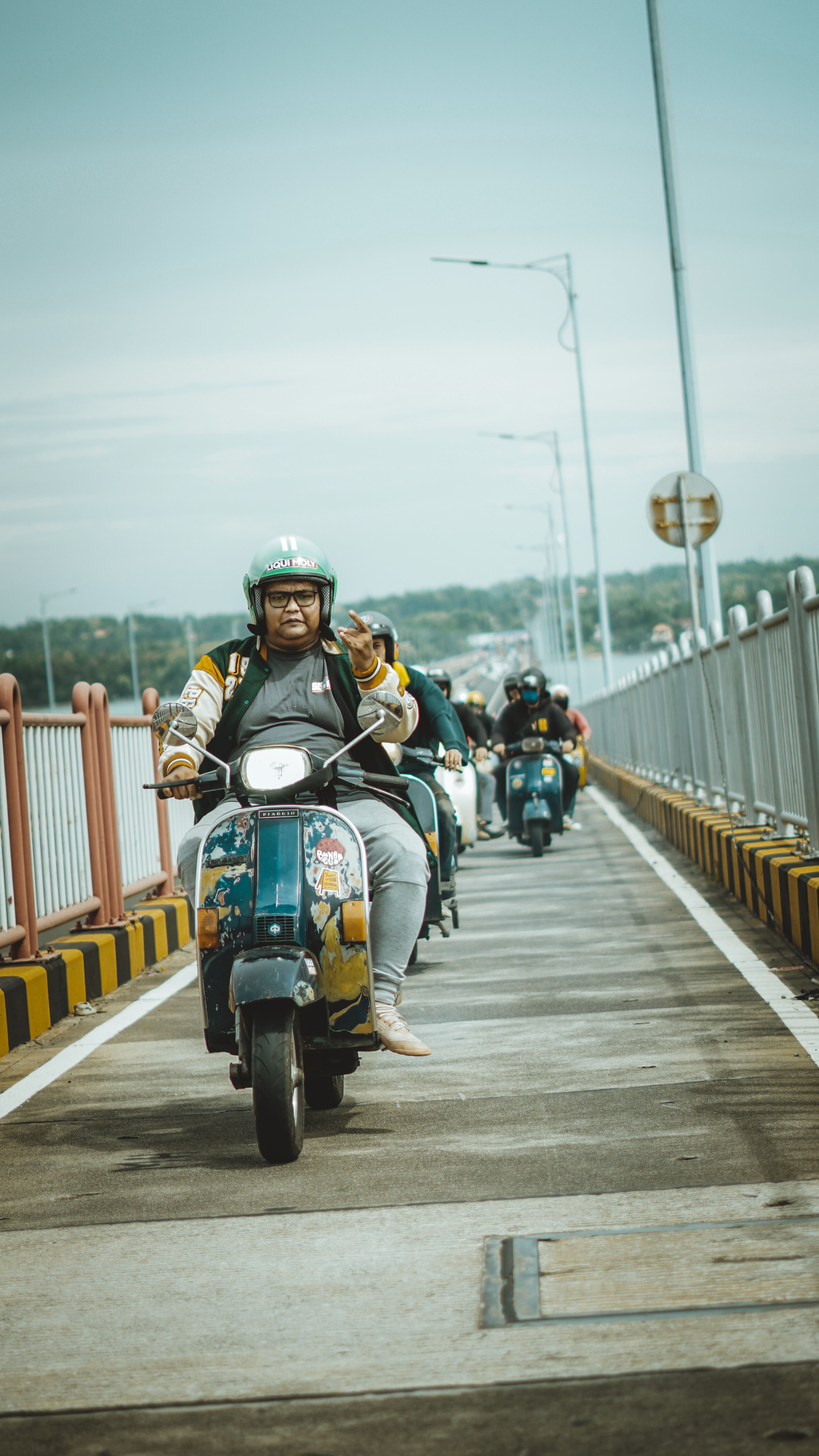 Group Riding Vespas on Indonesian Bridge · Free Stock Photo