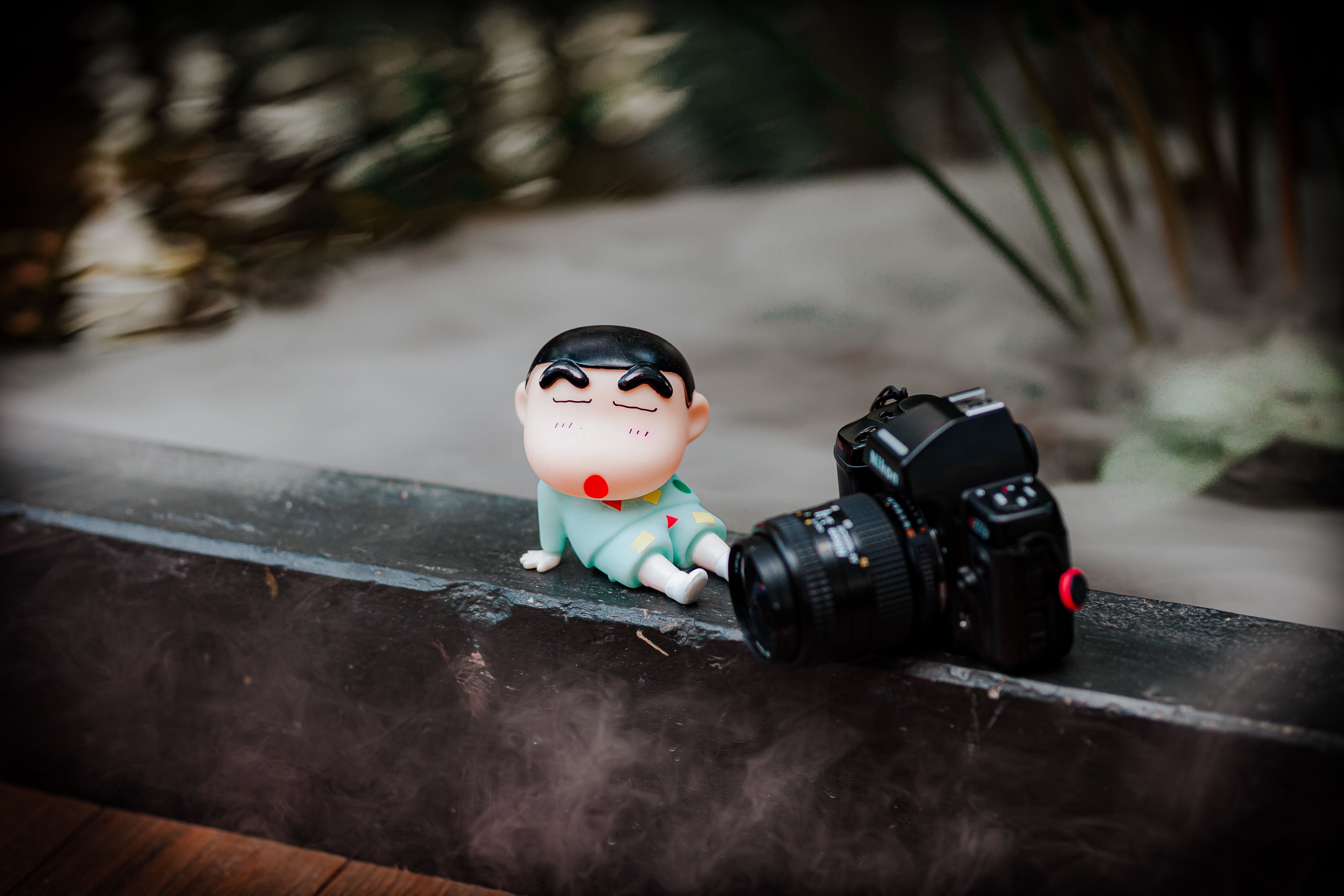 Toy Figurine and Camera on Wooden Surface · Free Stock Photo