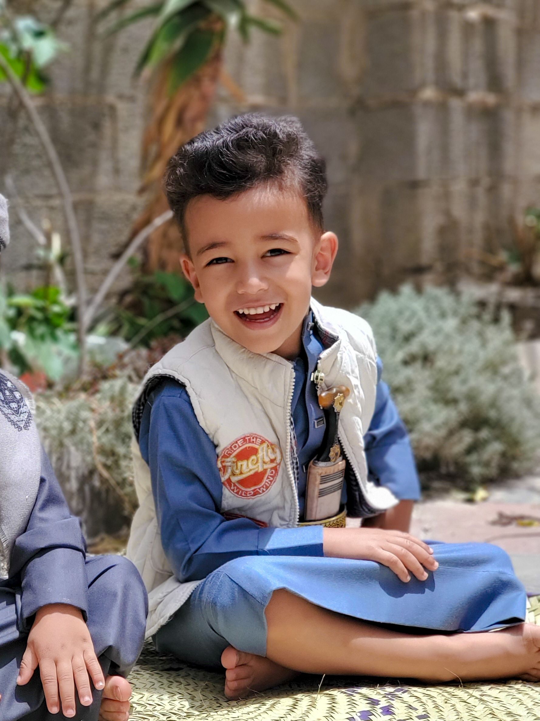 Smiling Boy in Traditional Yemeni Attire Outdoors · Free Stock Photo