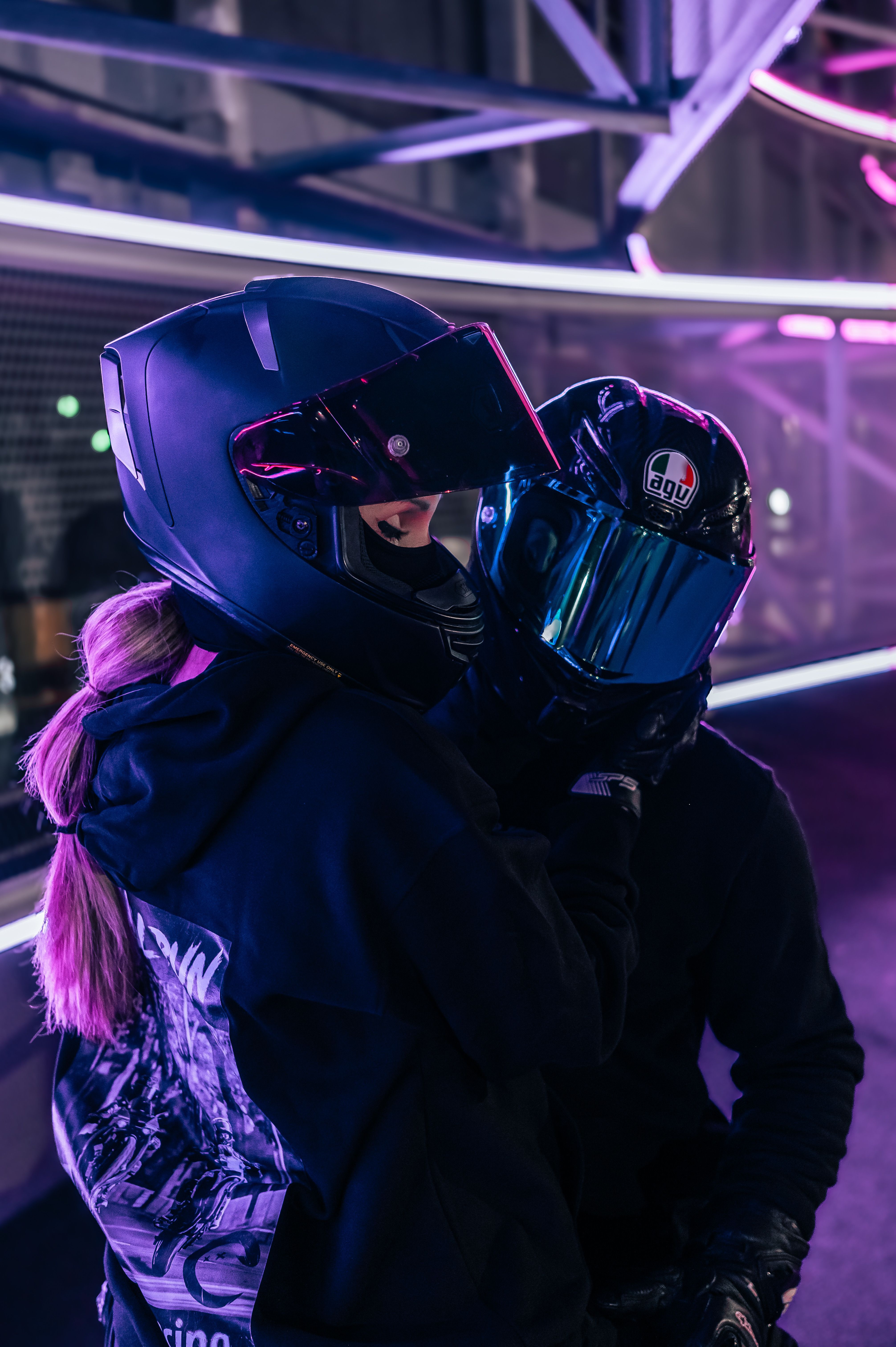 Couple in Motorcycle Helmets Embracing at Night · Free Stock Photo