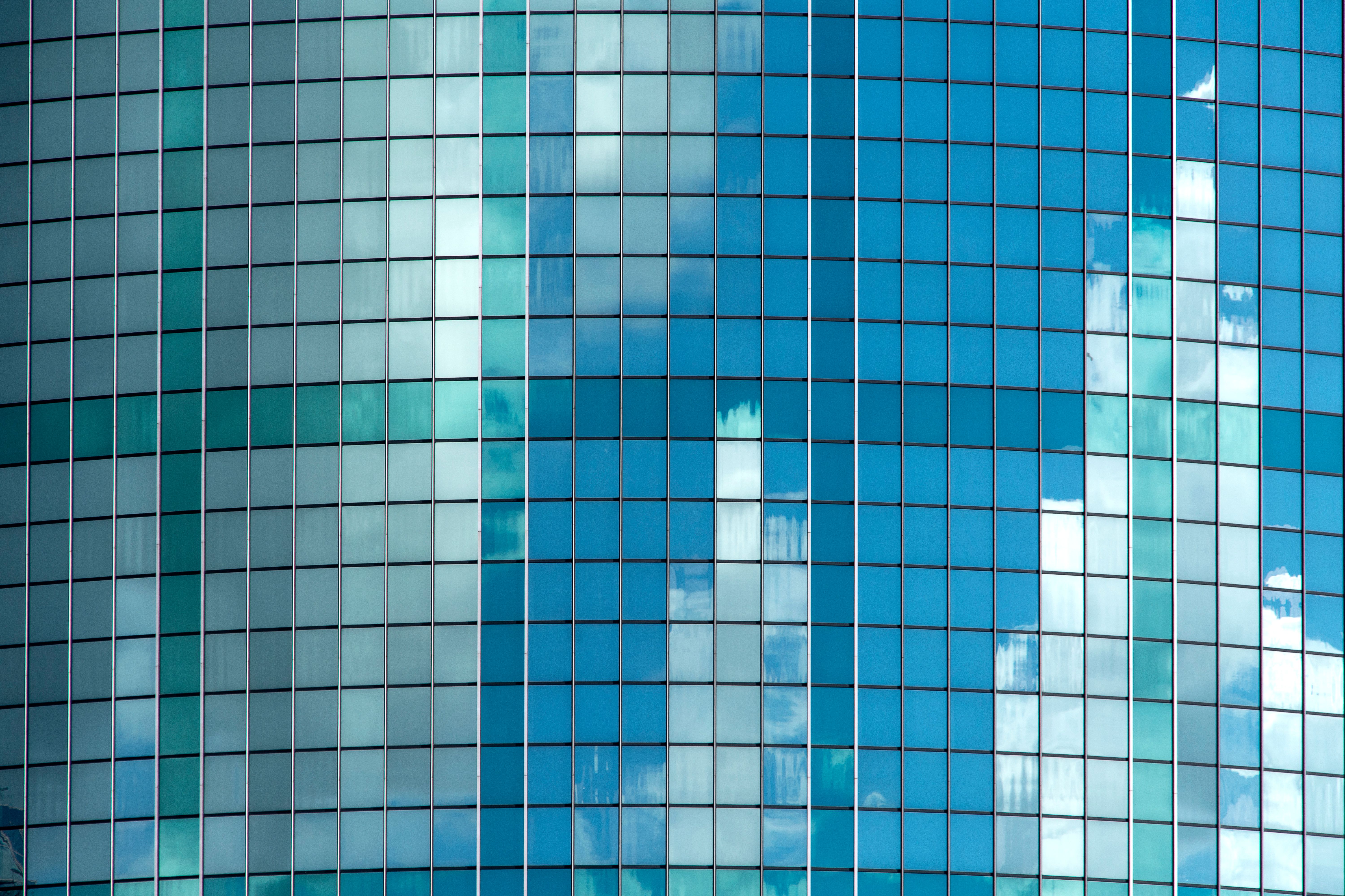 Modern Glass Facade with Cloud Reflections in Rotterdam · Free Stock Photo