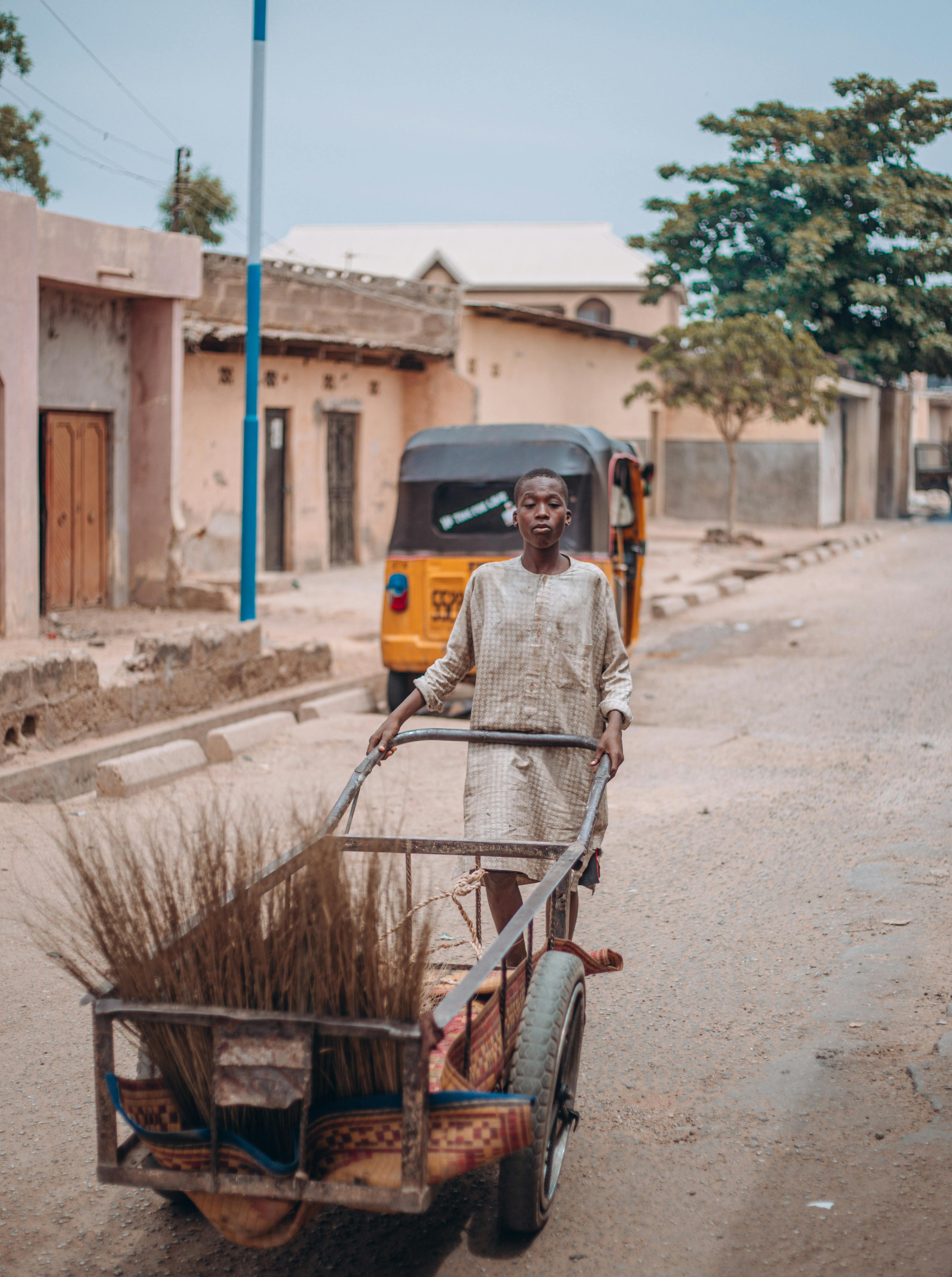 Man Pulling Cart on Urban Street in Africa · Free Stock Photo