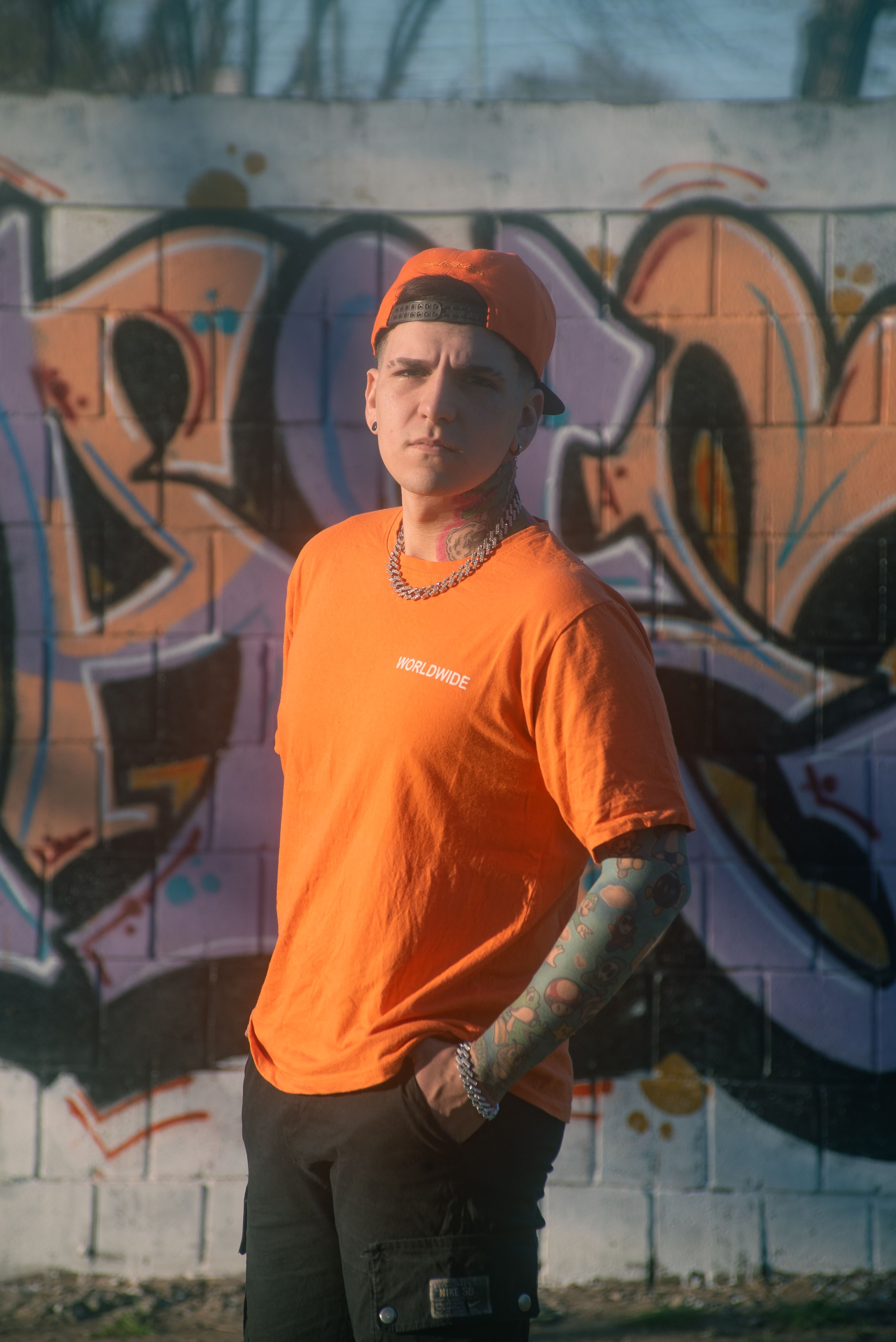 Urban Portrait of Tattooed Man in Orange Shirt · Free Stock Photo