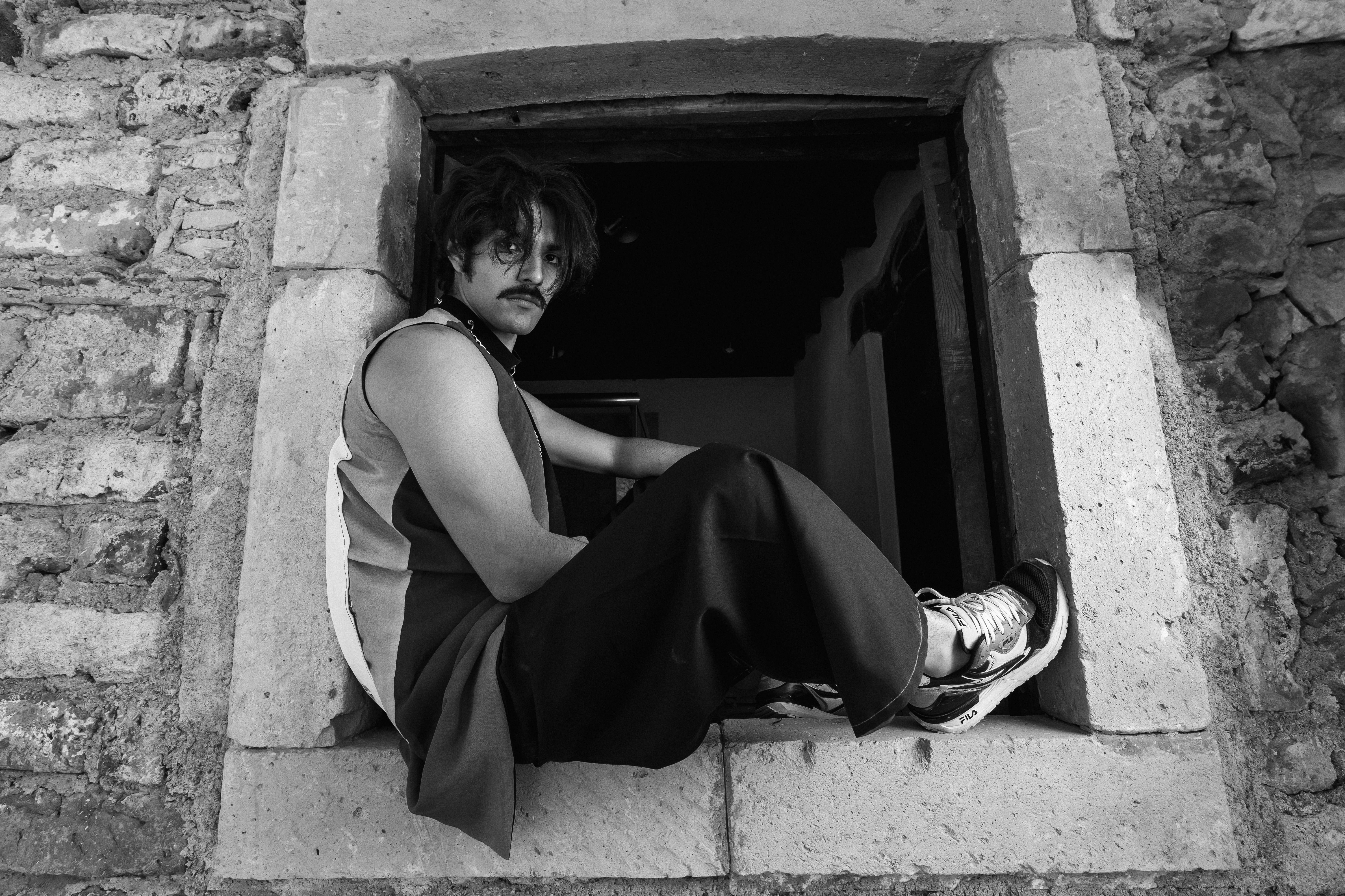 Moody Portrait of a Man Seated in Window Frame · Free Stock Photo