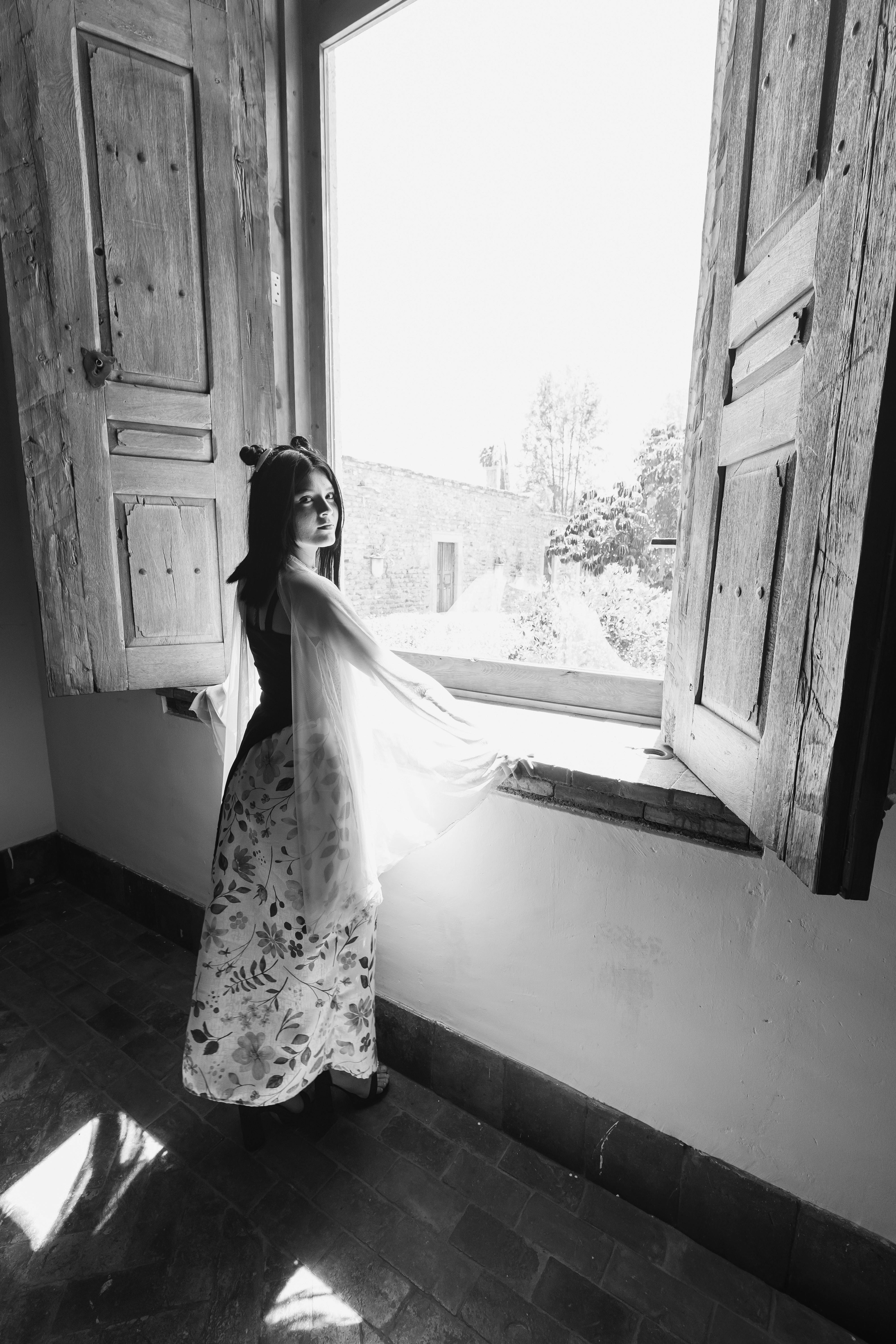 Elegant Woman Gazing out a Rustic Window · Free Stock Photo