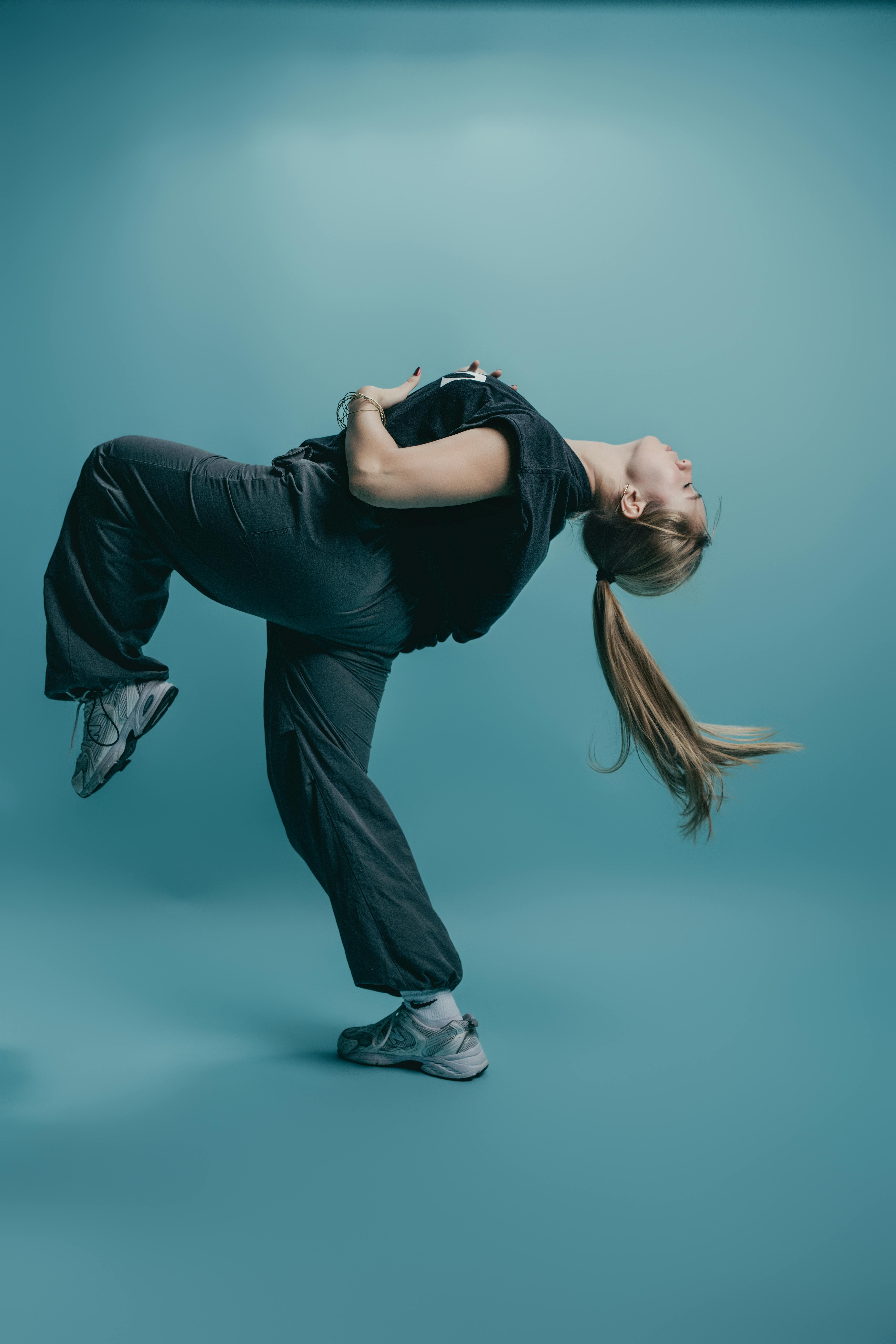 Dynamic Dance Pose Against Blue Backdrop · Free Stock Photo