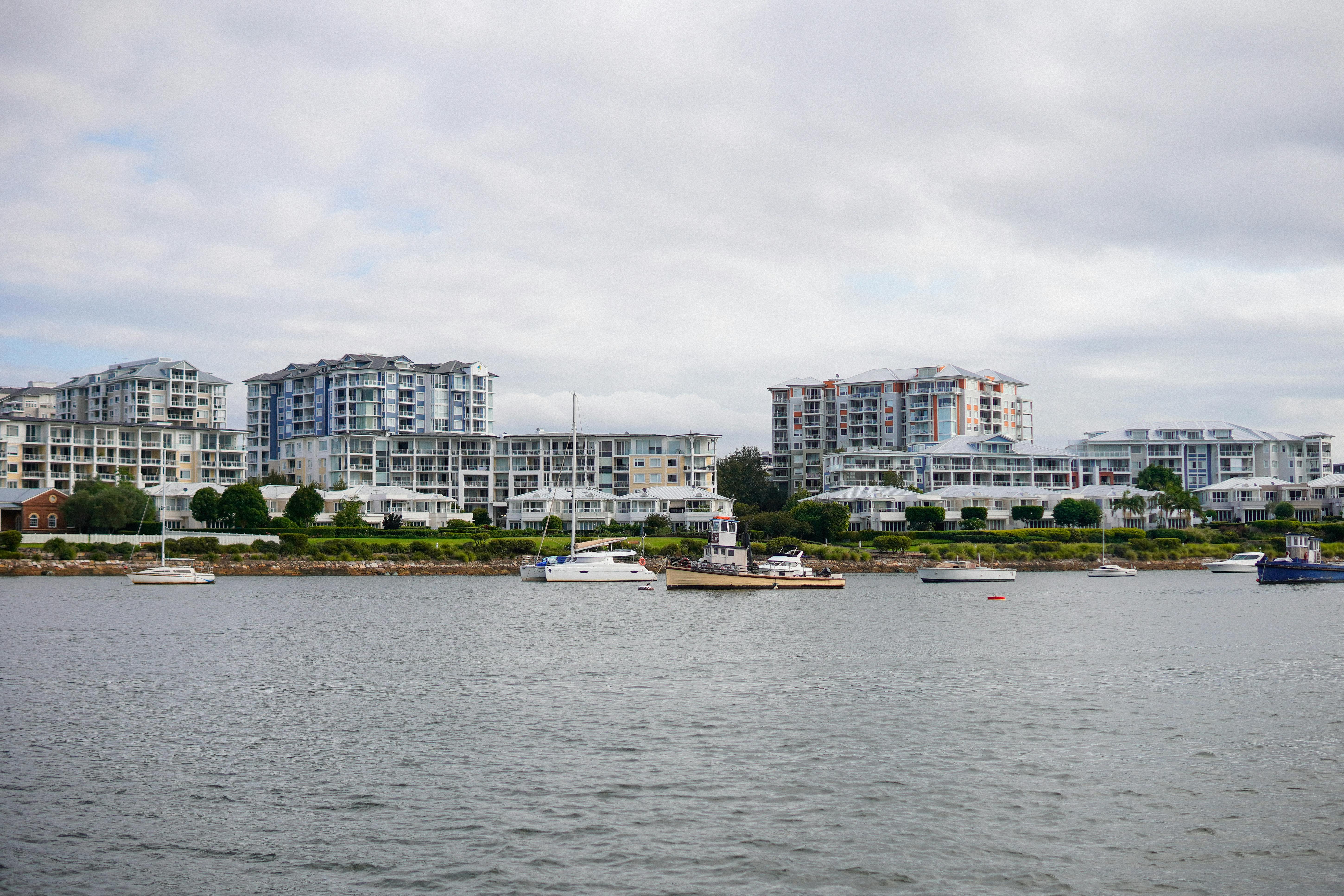Modern Seaside Buildings with Sailboats in Harbor · Free Stock Photo