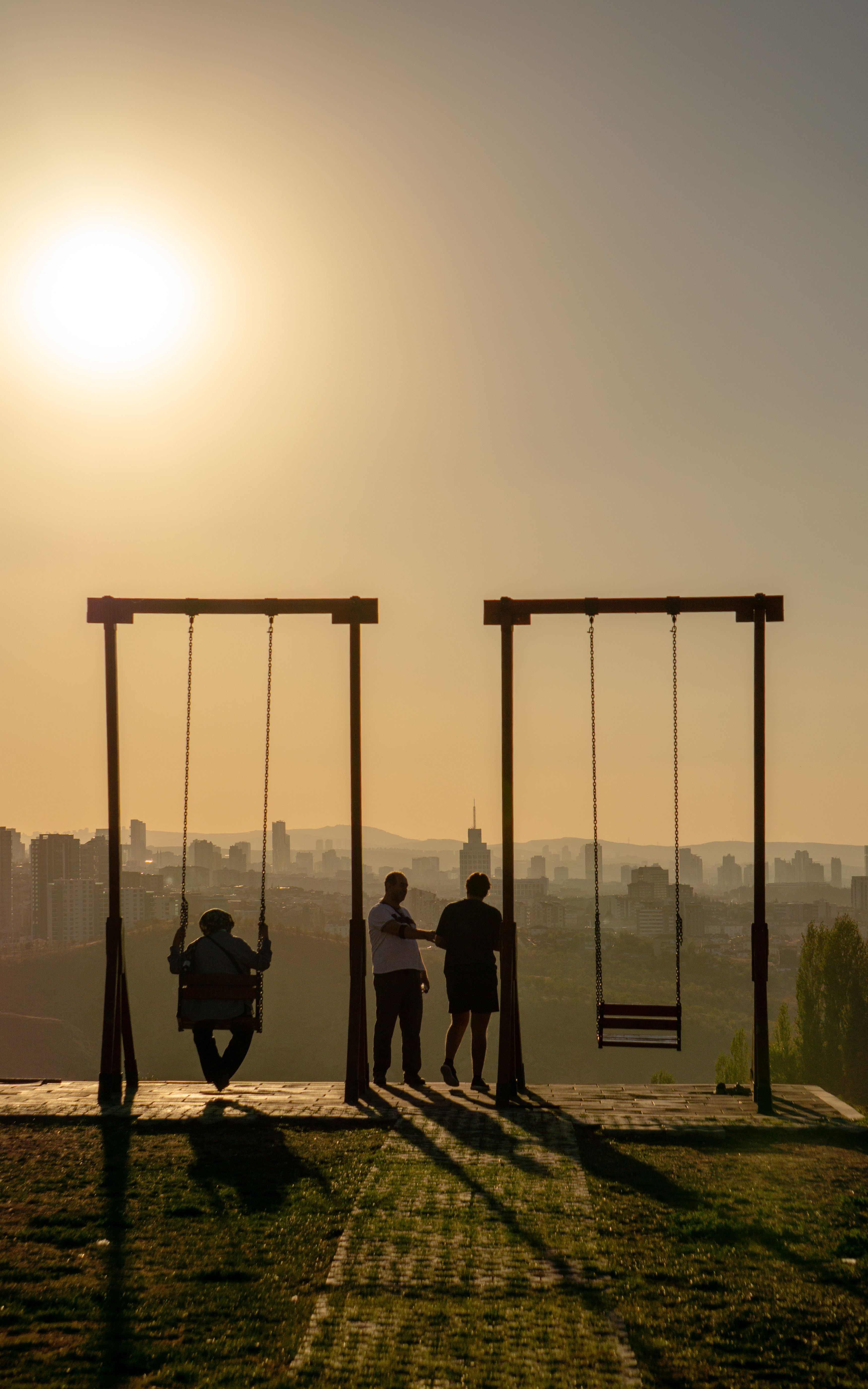 Silhouetted Group Watching Sunset on Swings · Free Stock Photo