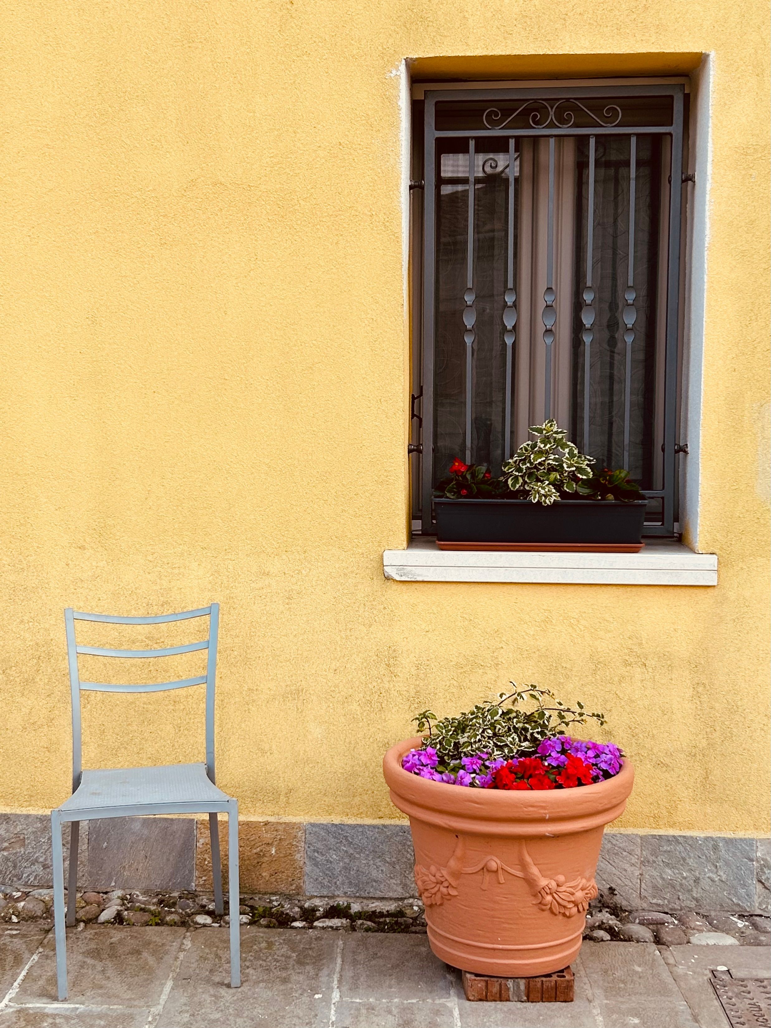 Charming Yellow Facade with Flowers and Chair · Free Stock Photo