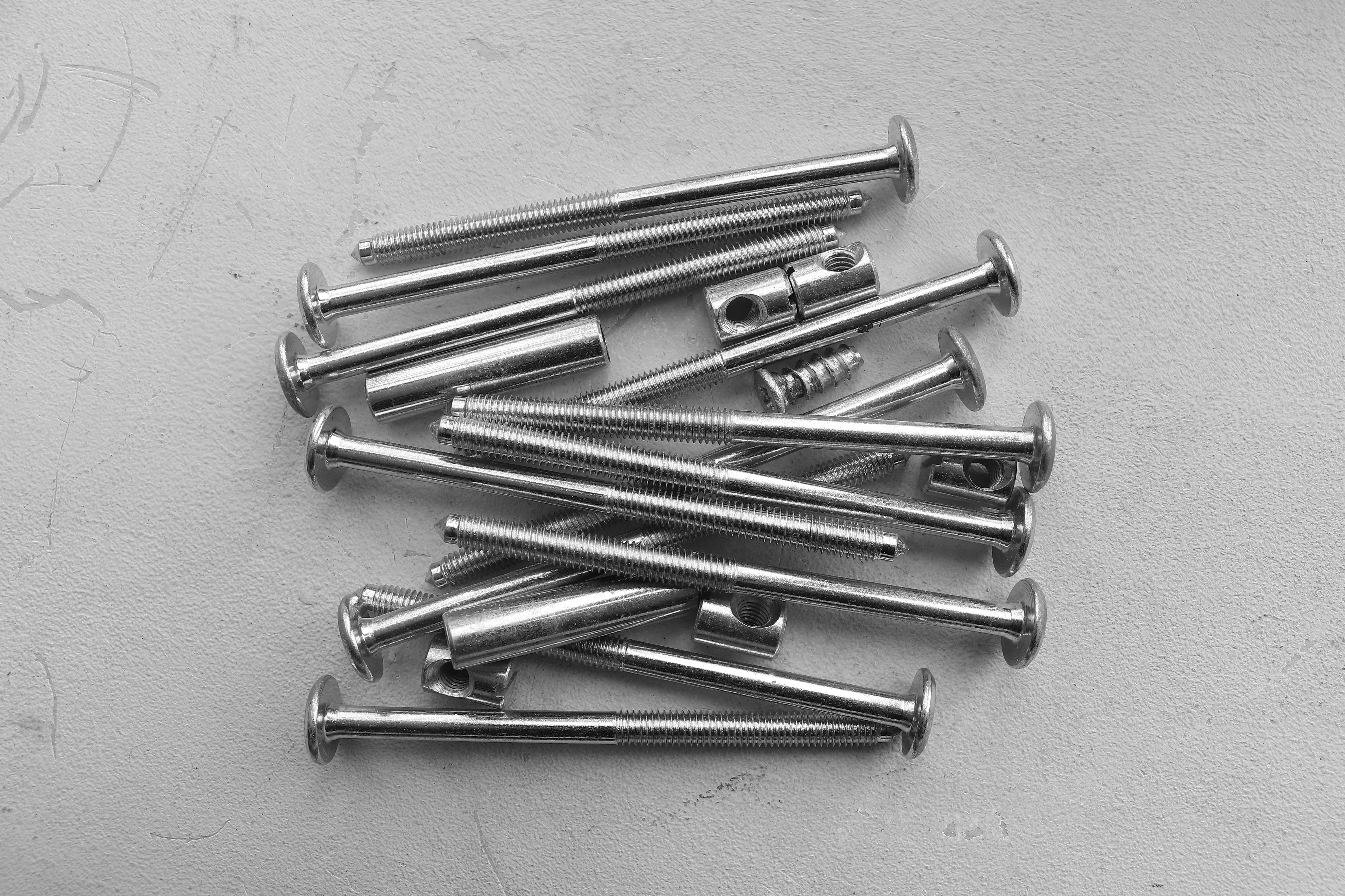 Metal Screws and Bolts on a White Surface · Free Stock Photo