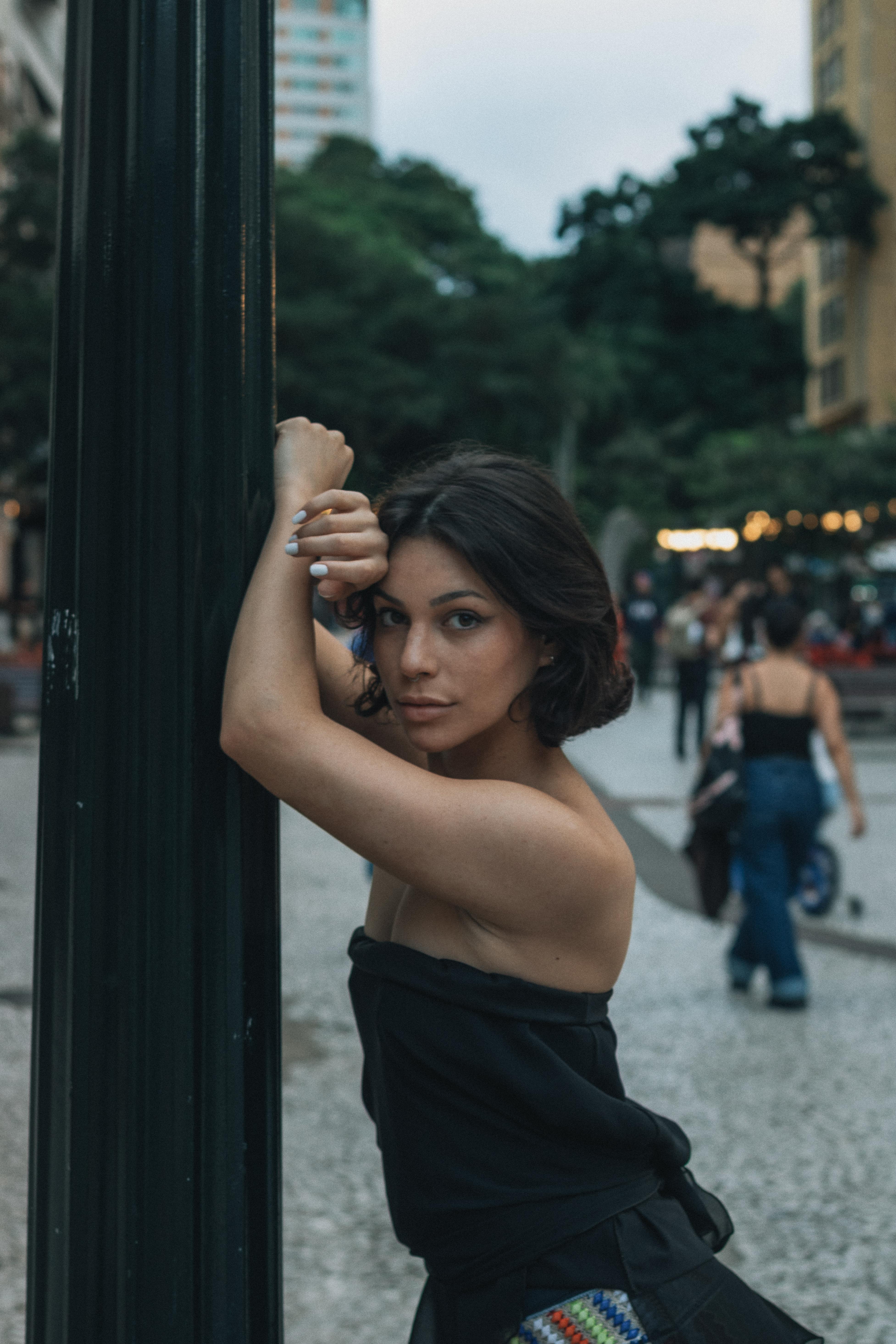 Stylish Woman Leaning on Urban Lamp Post · Free Stock Photo