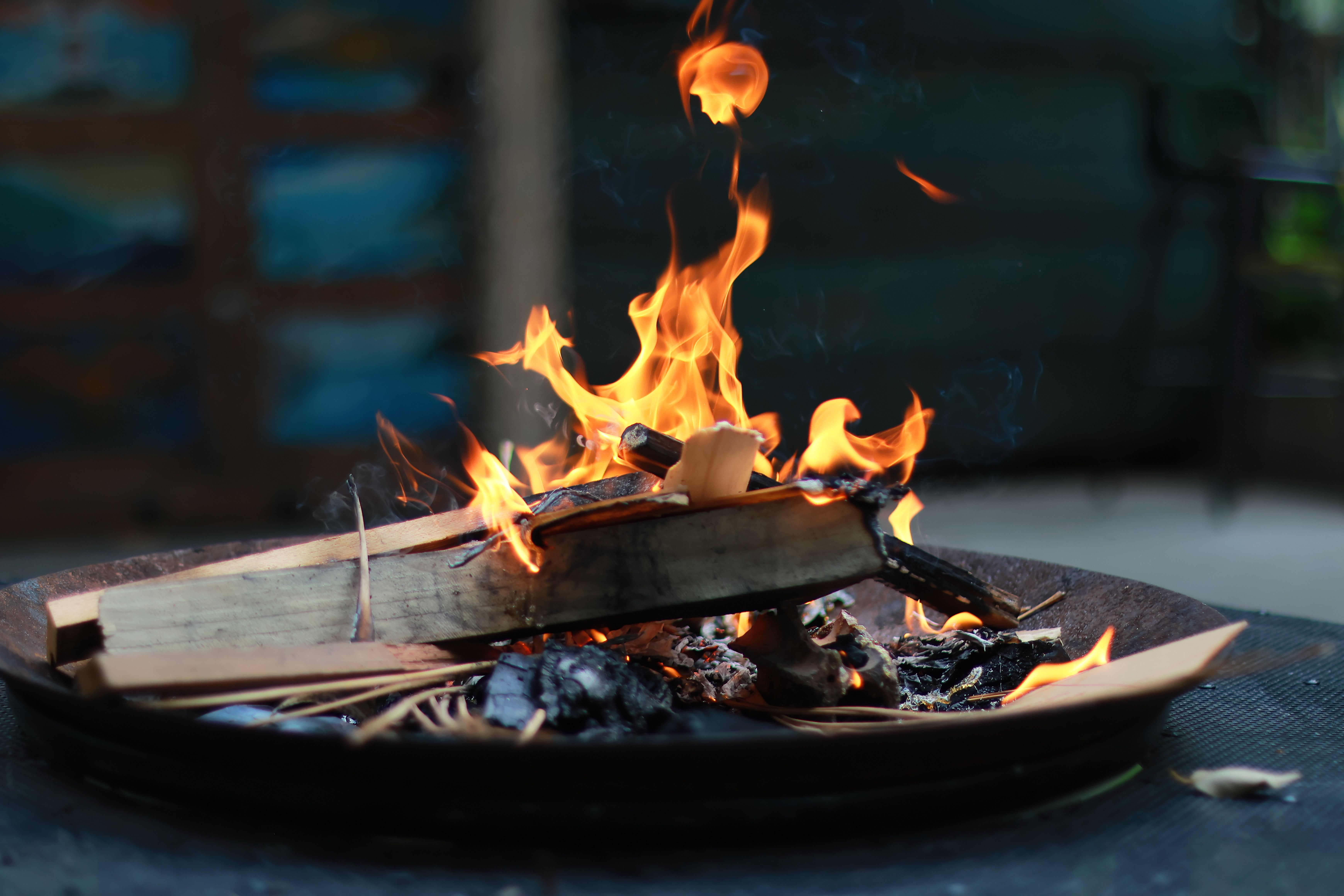 Firewood Burning in Black Steel Round Tray · Free Stock Photo