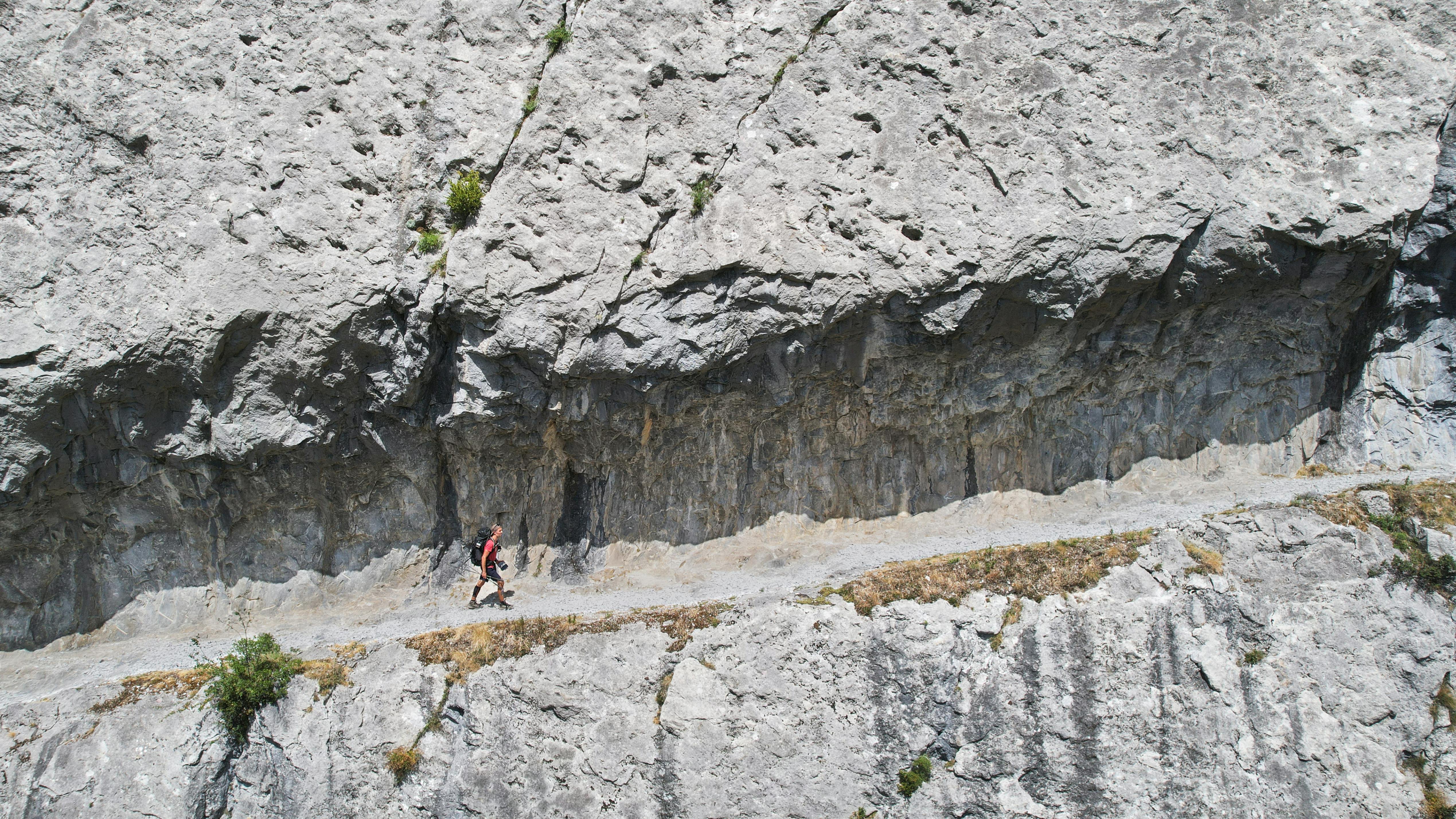 Hiker Traversing Rock Face in Pyrenees · Free Stock Photo